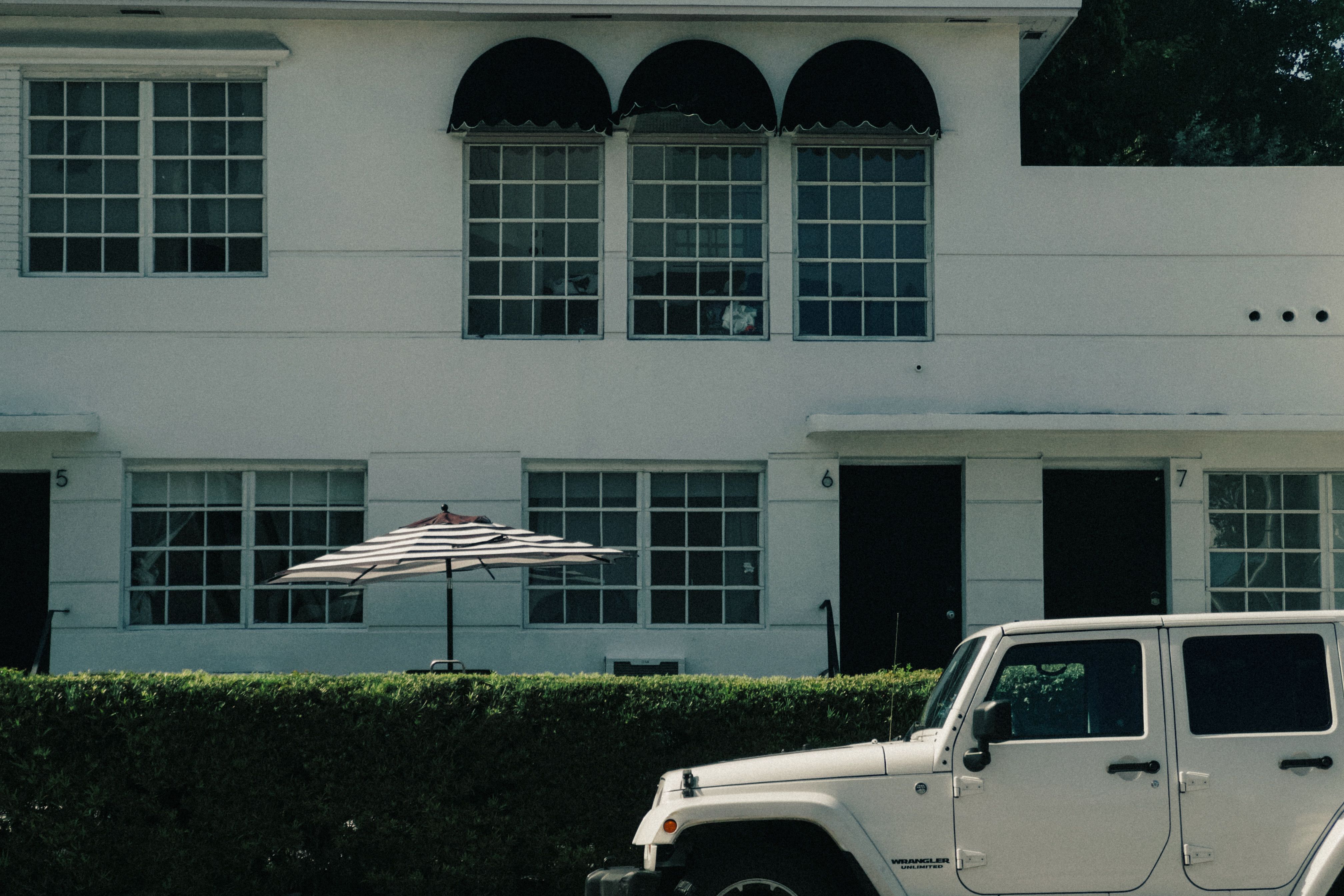 Modern Apartment Facade with Jeep and Umbrella · Free Stock Photo