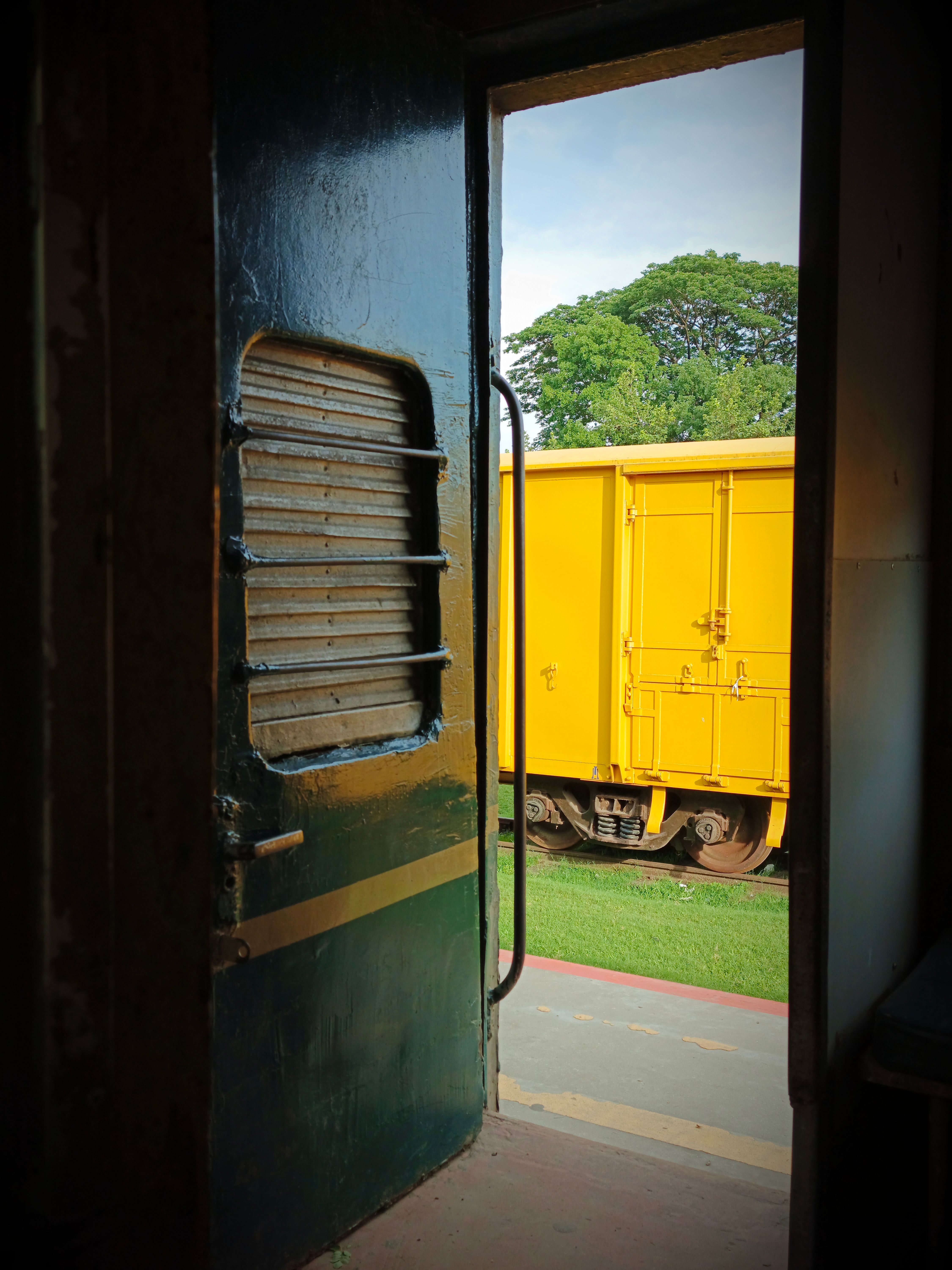 Open Train Door with View of Yellow Freight Car · Free Stock Photo