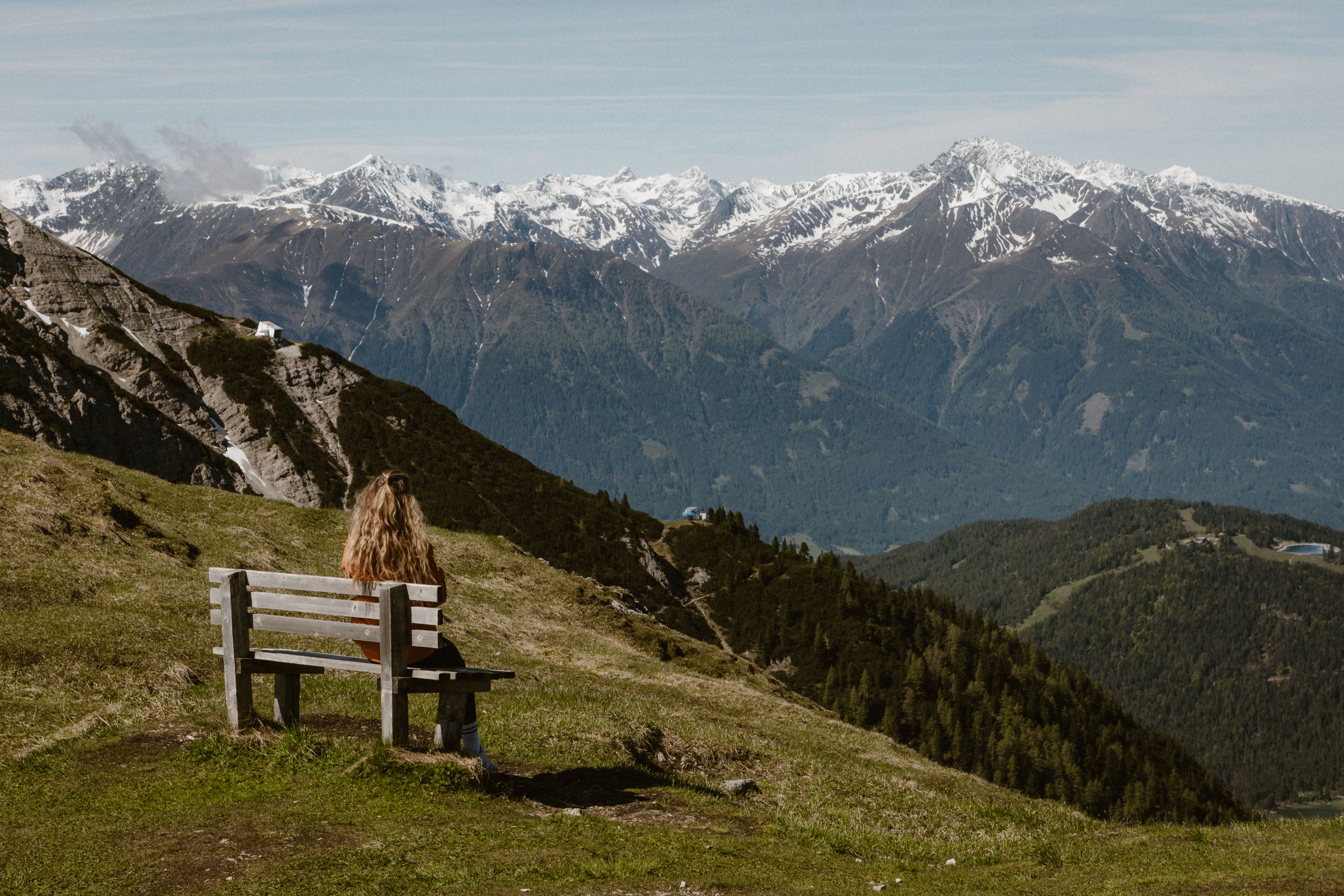 Woman Enjoying Mountain View from Wooden Bench · Free Stock Photo