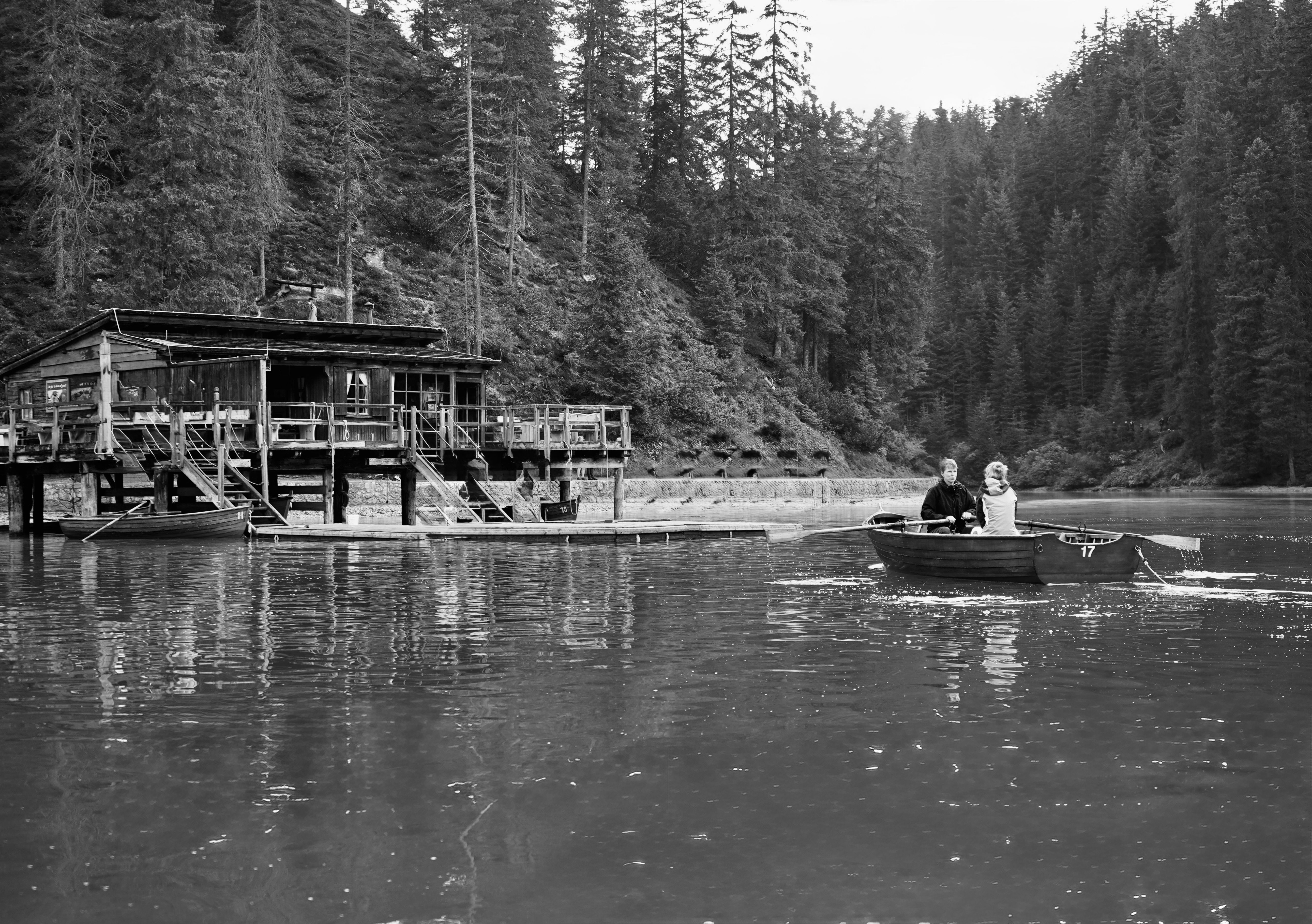Vintage Boating Scene with Rustic Cabin and Forest · Free Stock Photo
