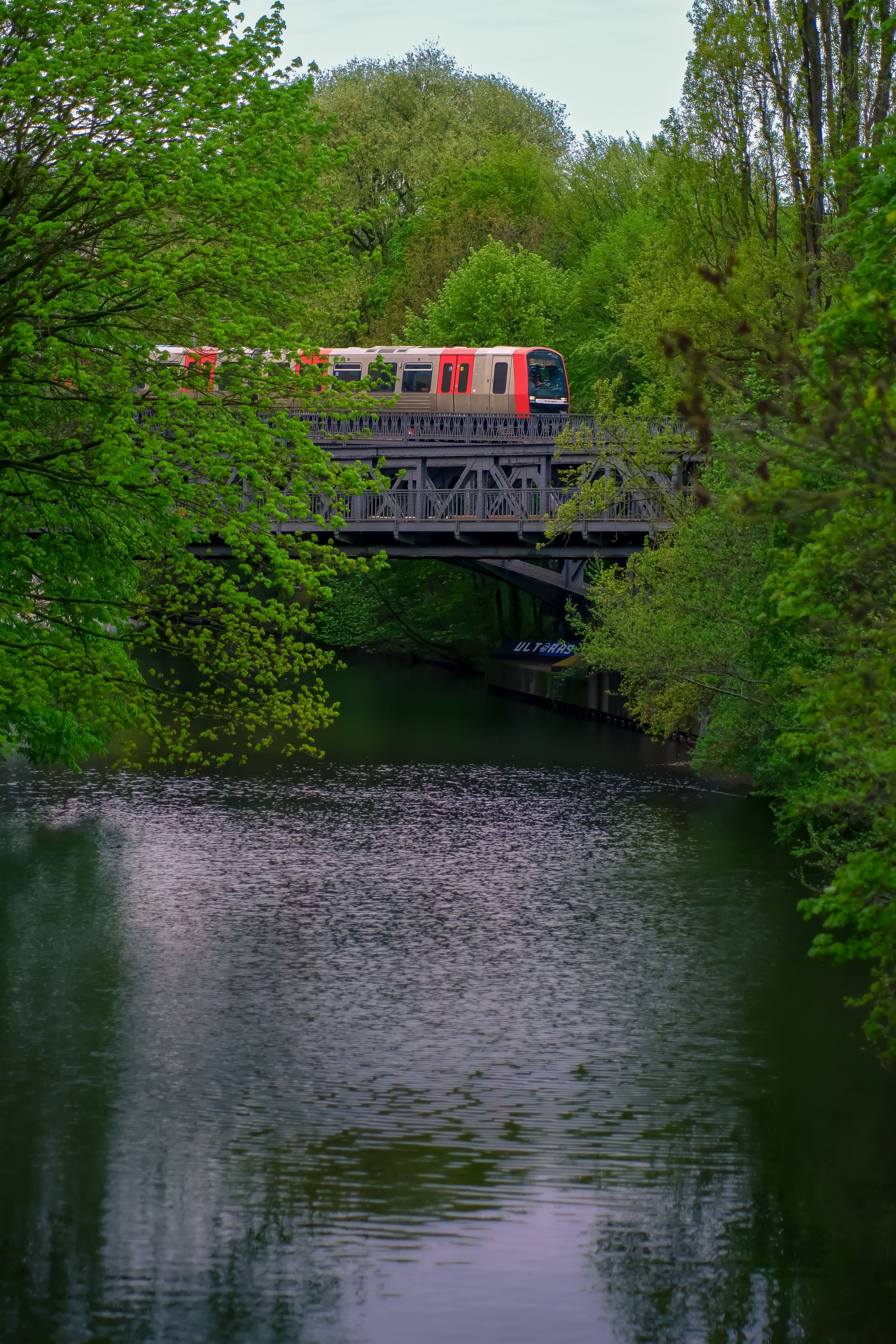 Train Crossing Bridge Over Serene River in Spring · Free Stock Photo