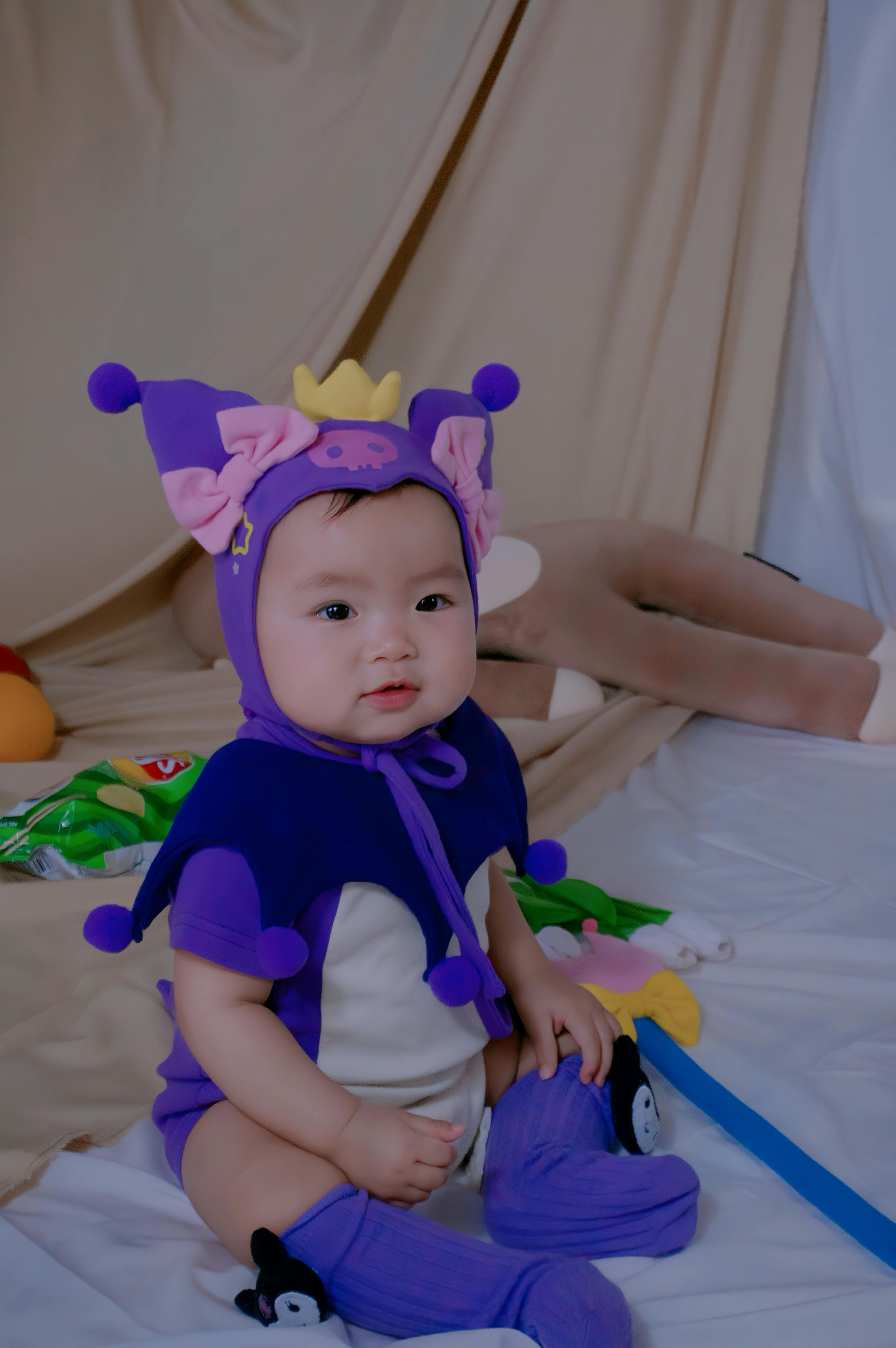 Adorable Baby in Purple Jester Costume Indoors · Free Stock Photo