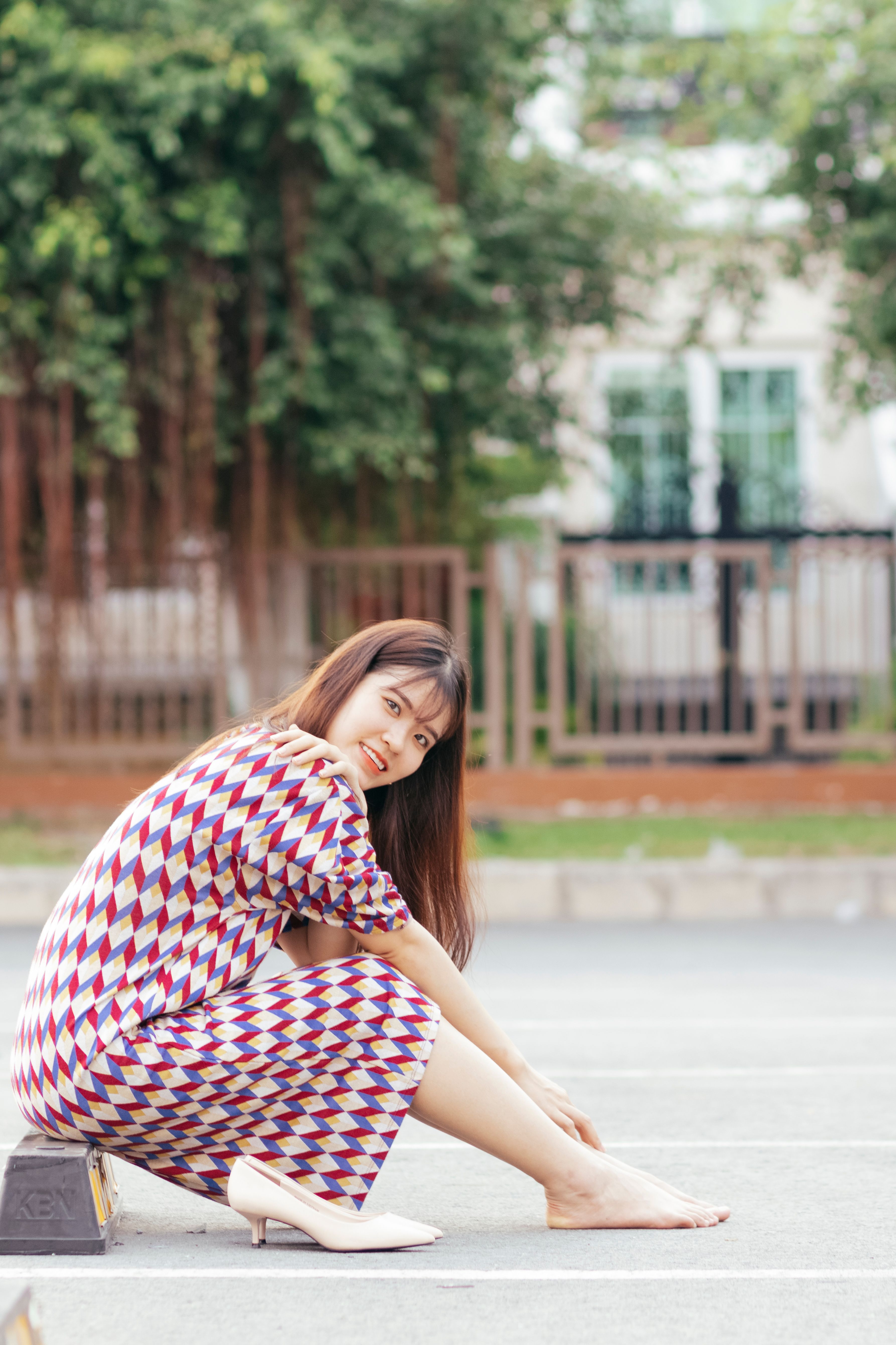 Woman in Printed Dress Sitting Down · Free Stock Photo