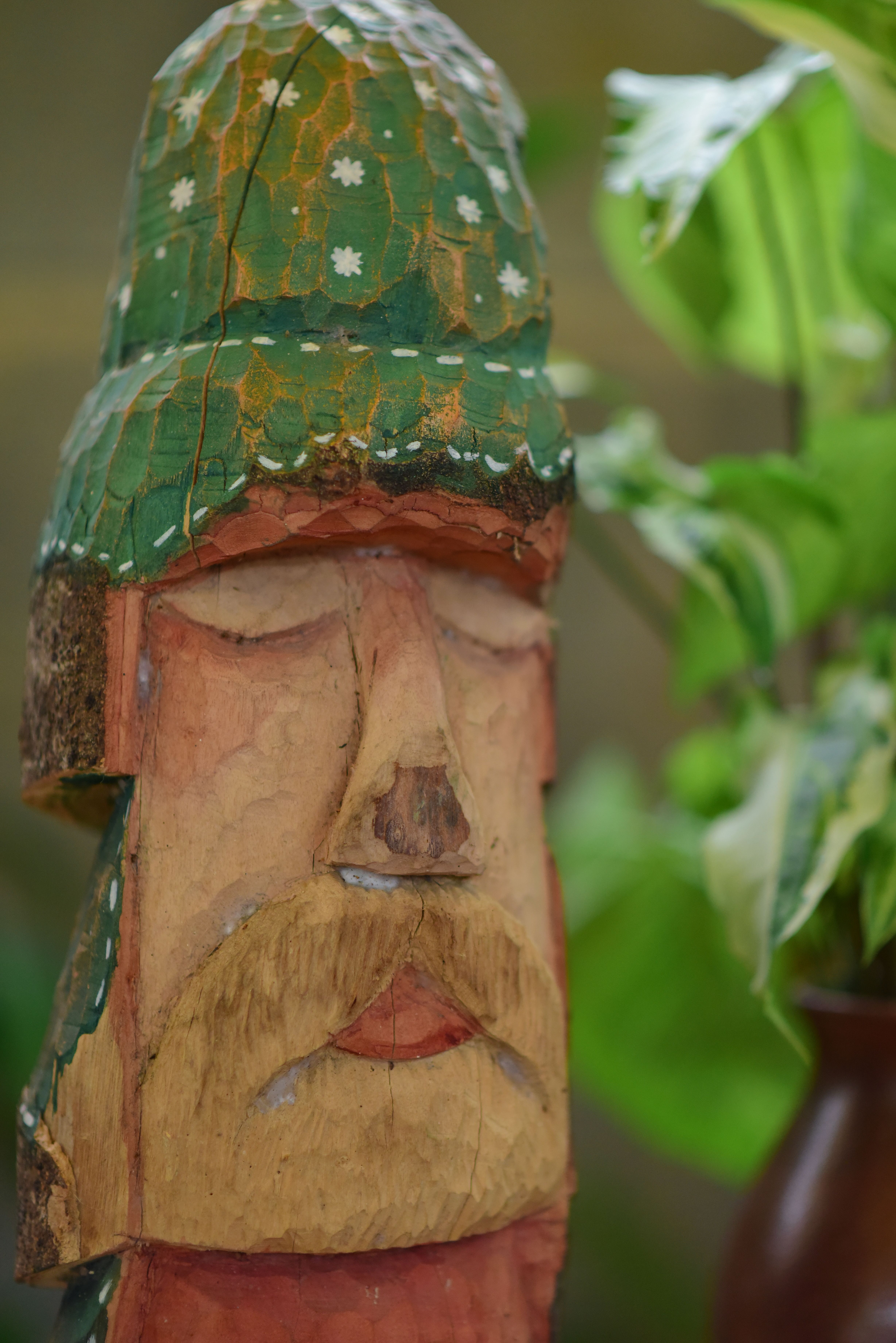 Hand-Carved Wooden Statue with Leafy Background · Free Stock Photo