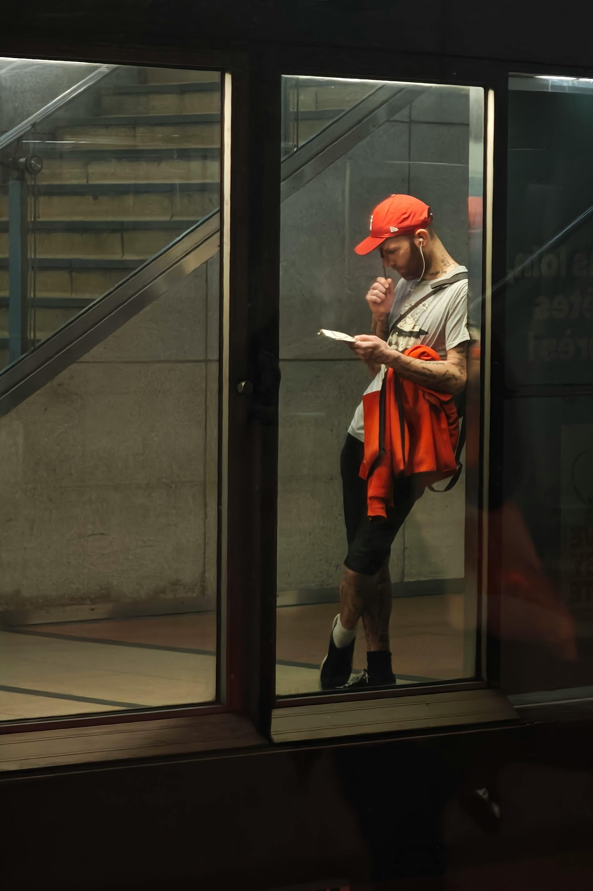 Young man in subway reading a book quietly · Free Stock Photo