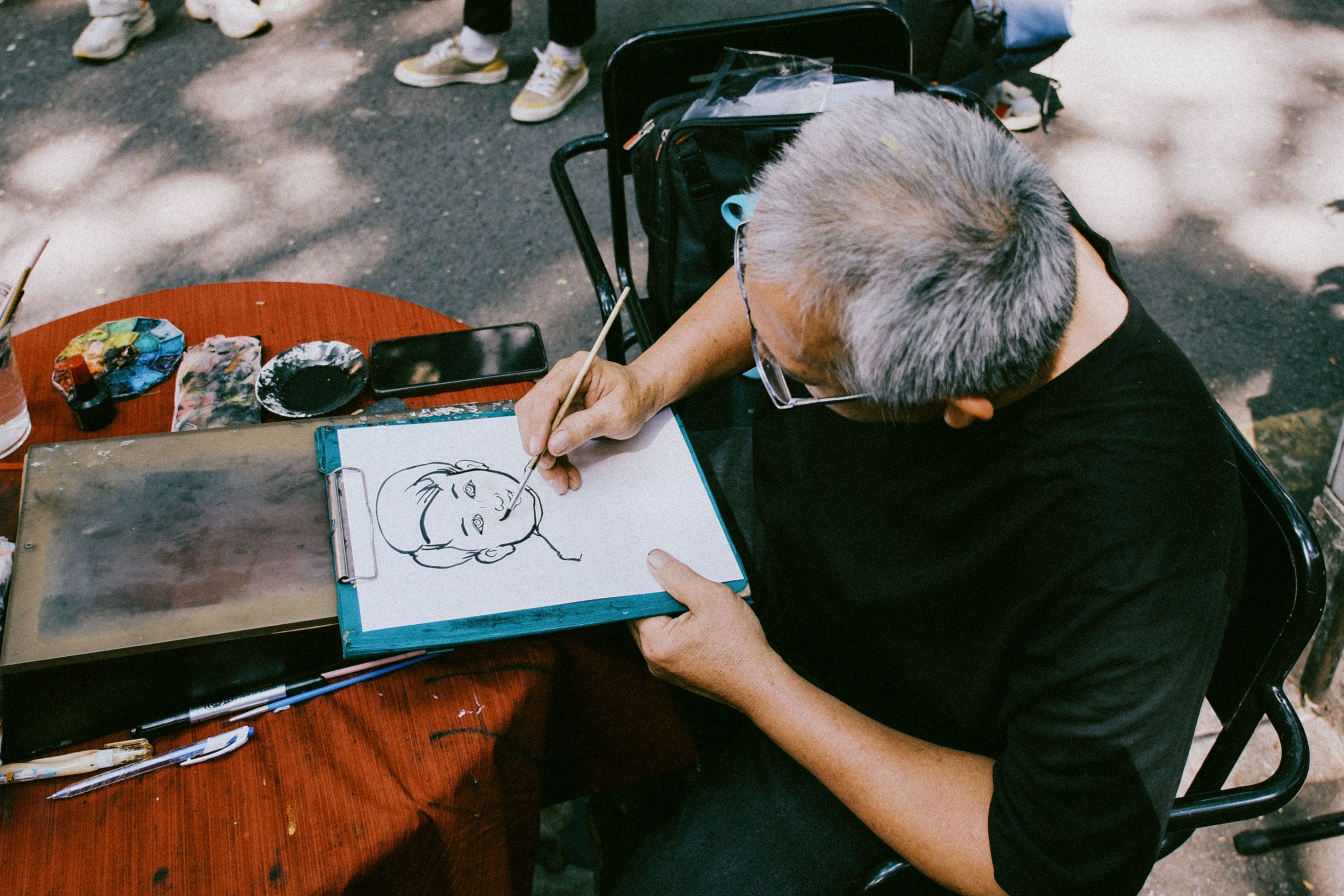Street Artist Drawing Portrait Outdoors · Free Stock Photo