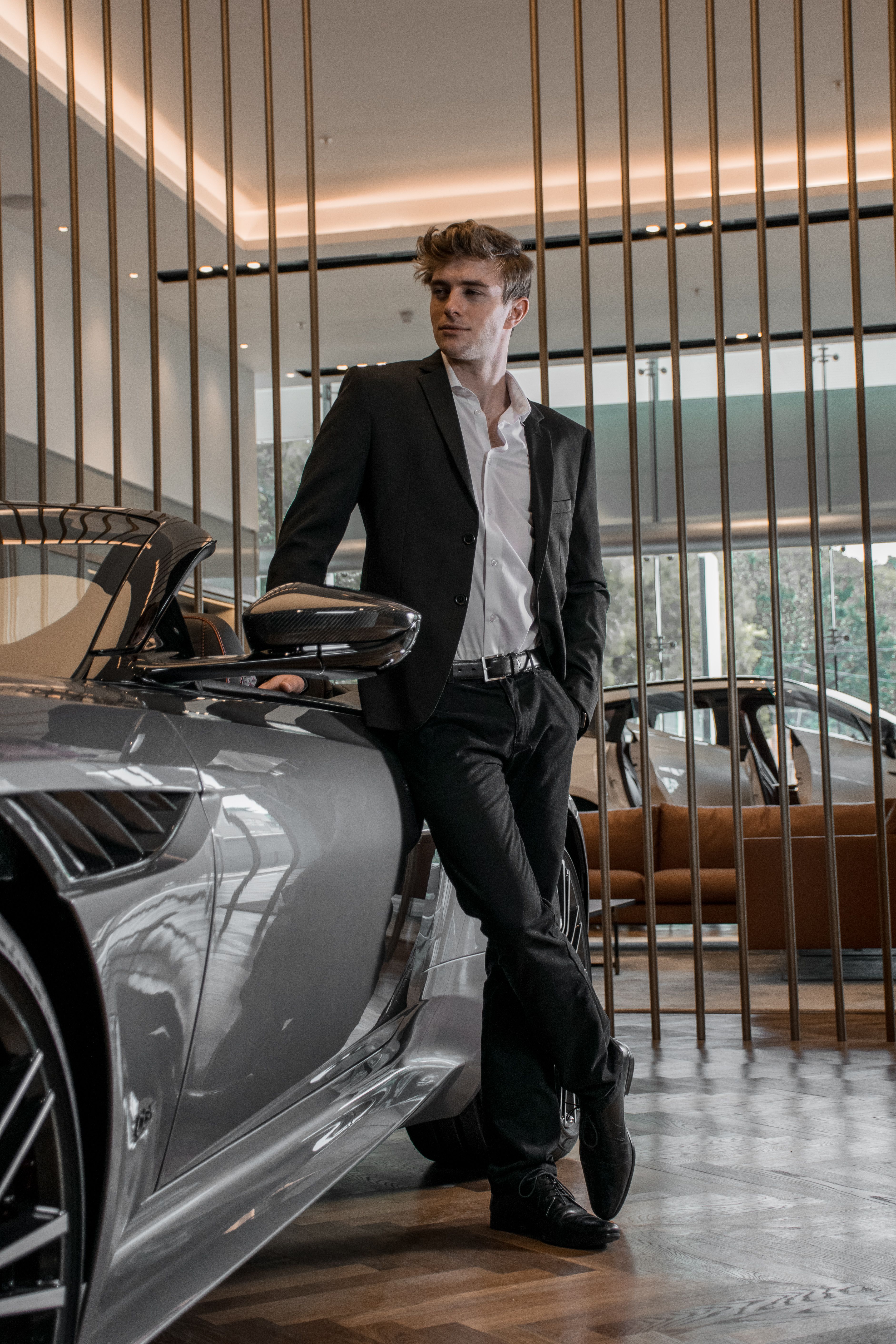 Elegant Man with Luxury Car in Showroom · Free Stock Photo