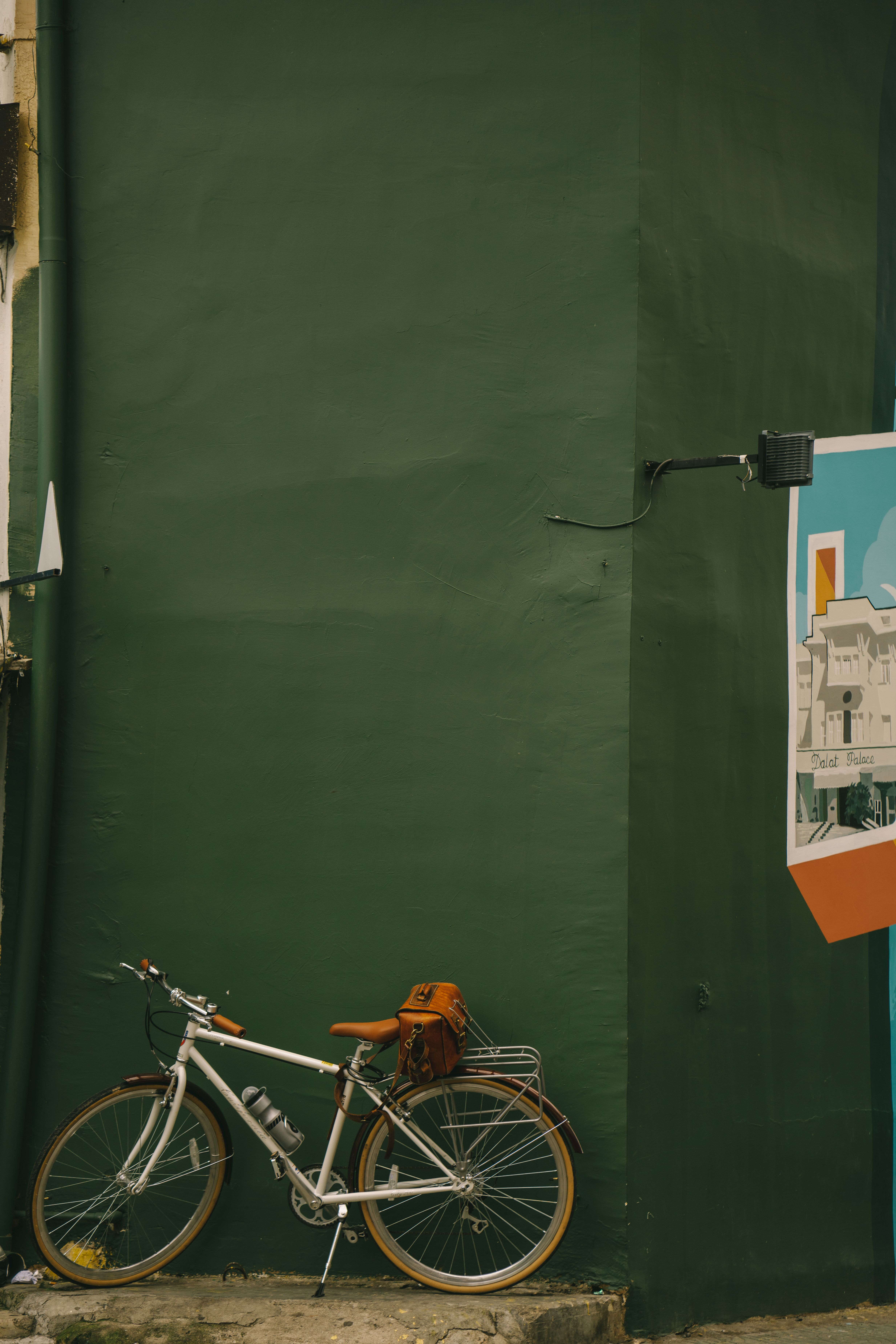 Bicycle Resting Against Green Wall in Đà Lạt · Free Stock Photo