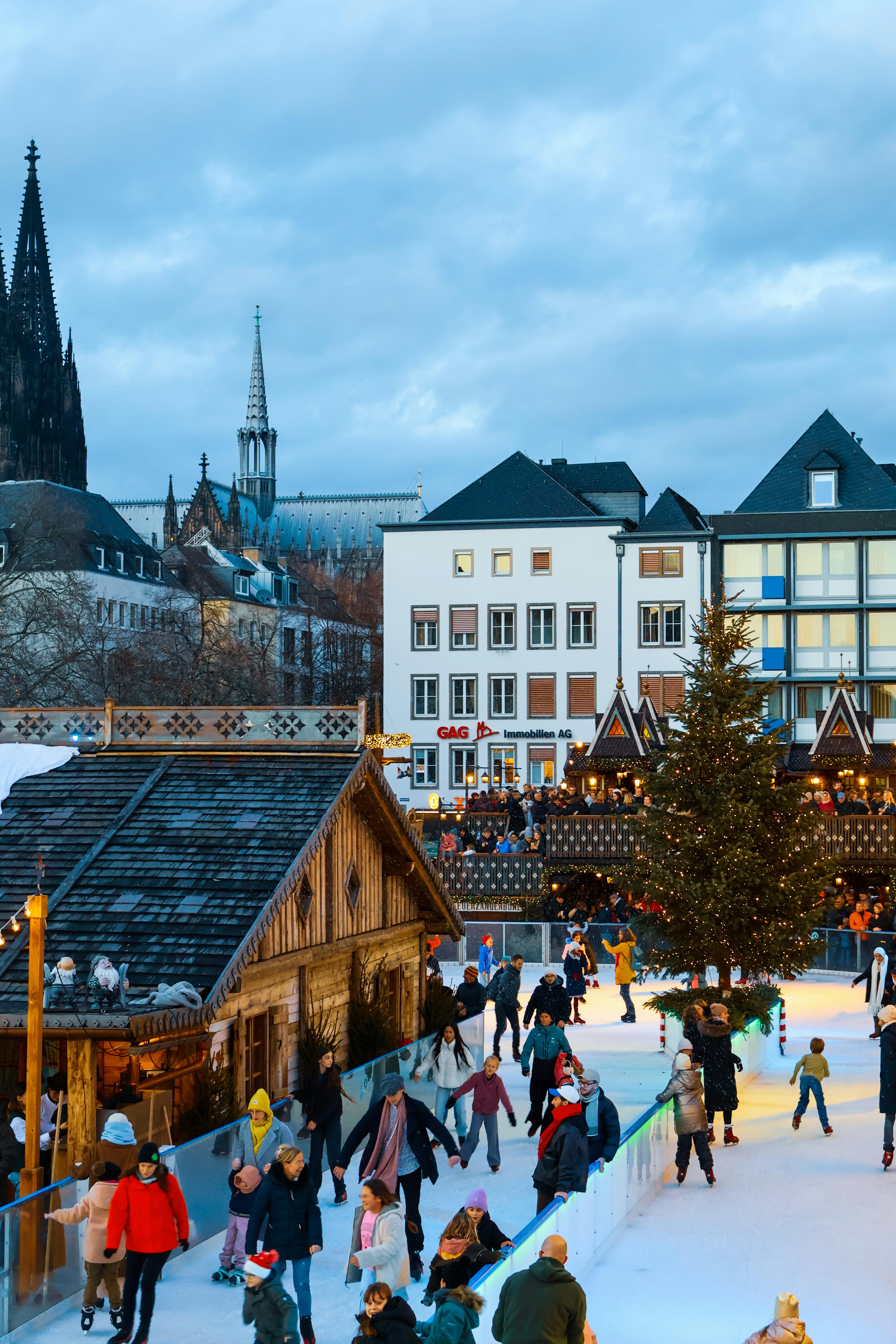 Festive Winter Ice Skating Scene in City Square · Free Stock Photo