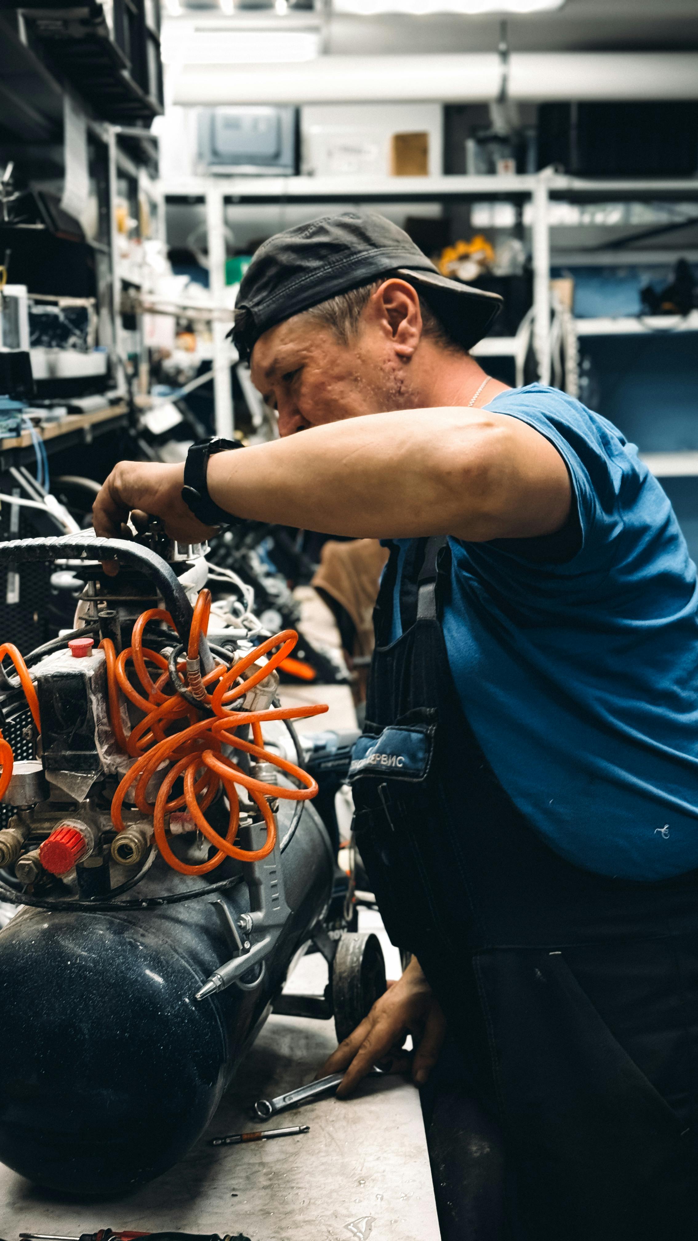 Self employed male mechanic working in garage · Free Stock Photo