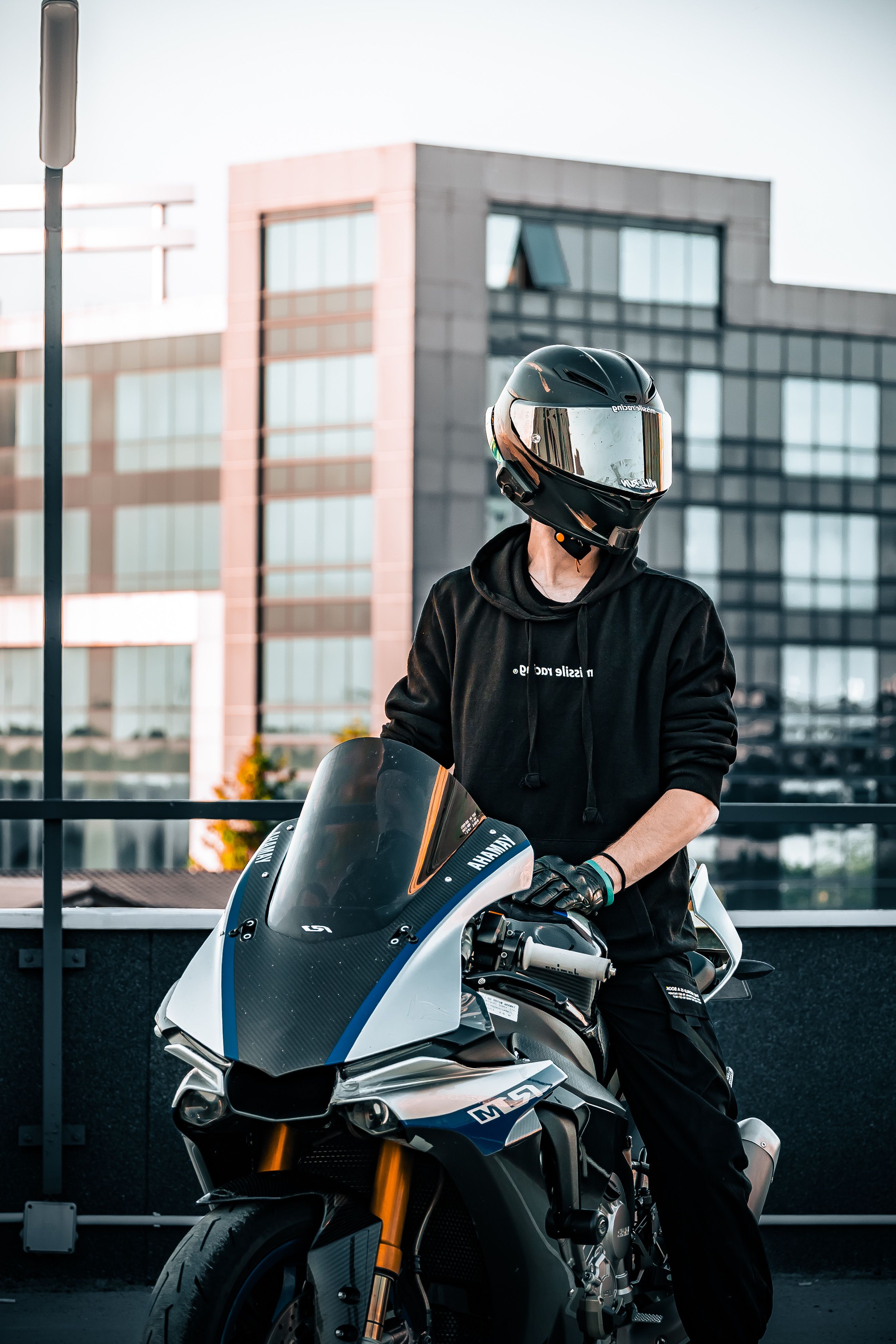 Urban motorcyclist with sleek helmet and modern bike · Free Stock Photo