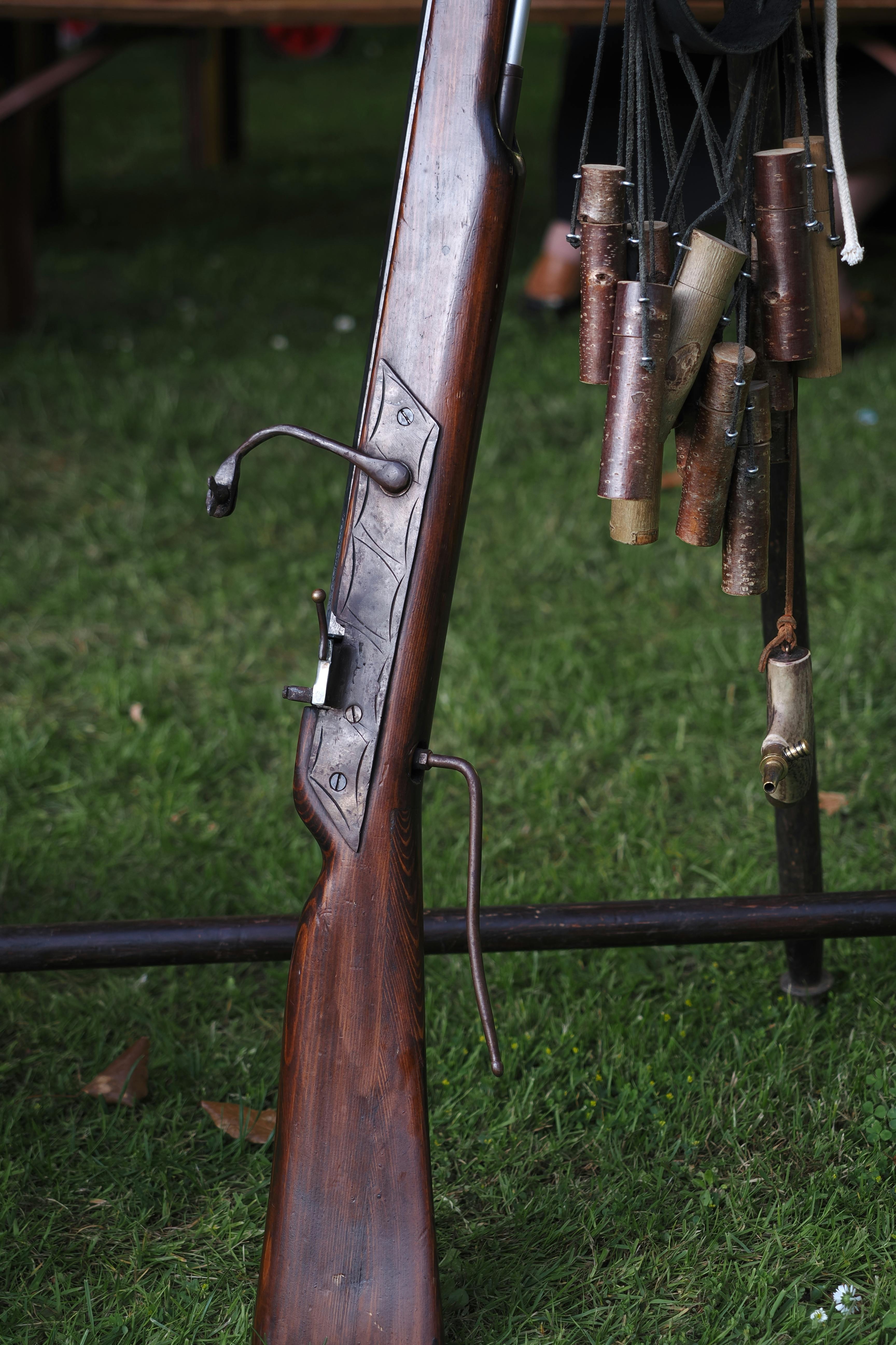 Man Assembling Rifle on Outdoor Table · Free Stock Photo