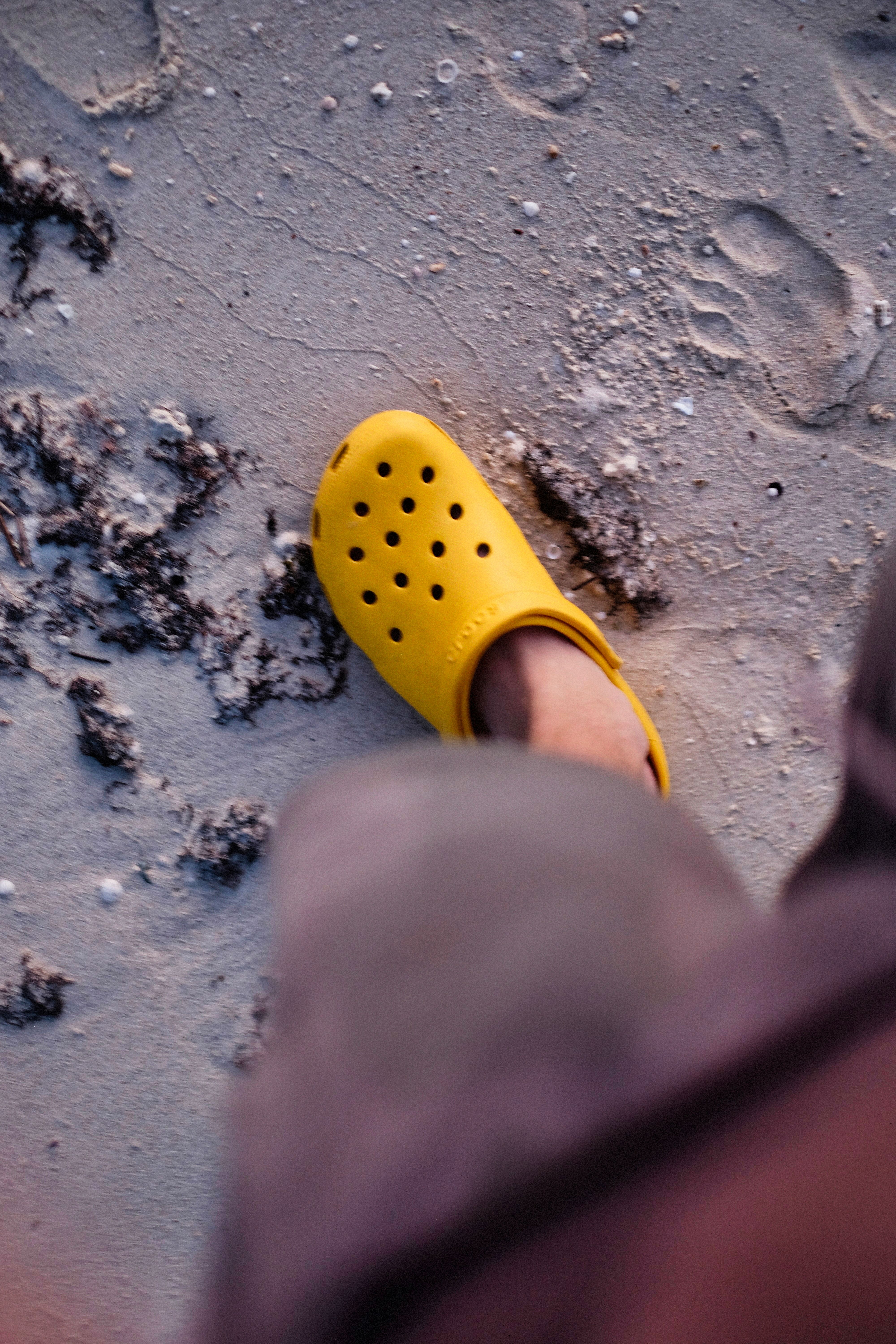 Yellow Crocs on Sandy Beach Shoreline · Free Stock Photo