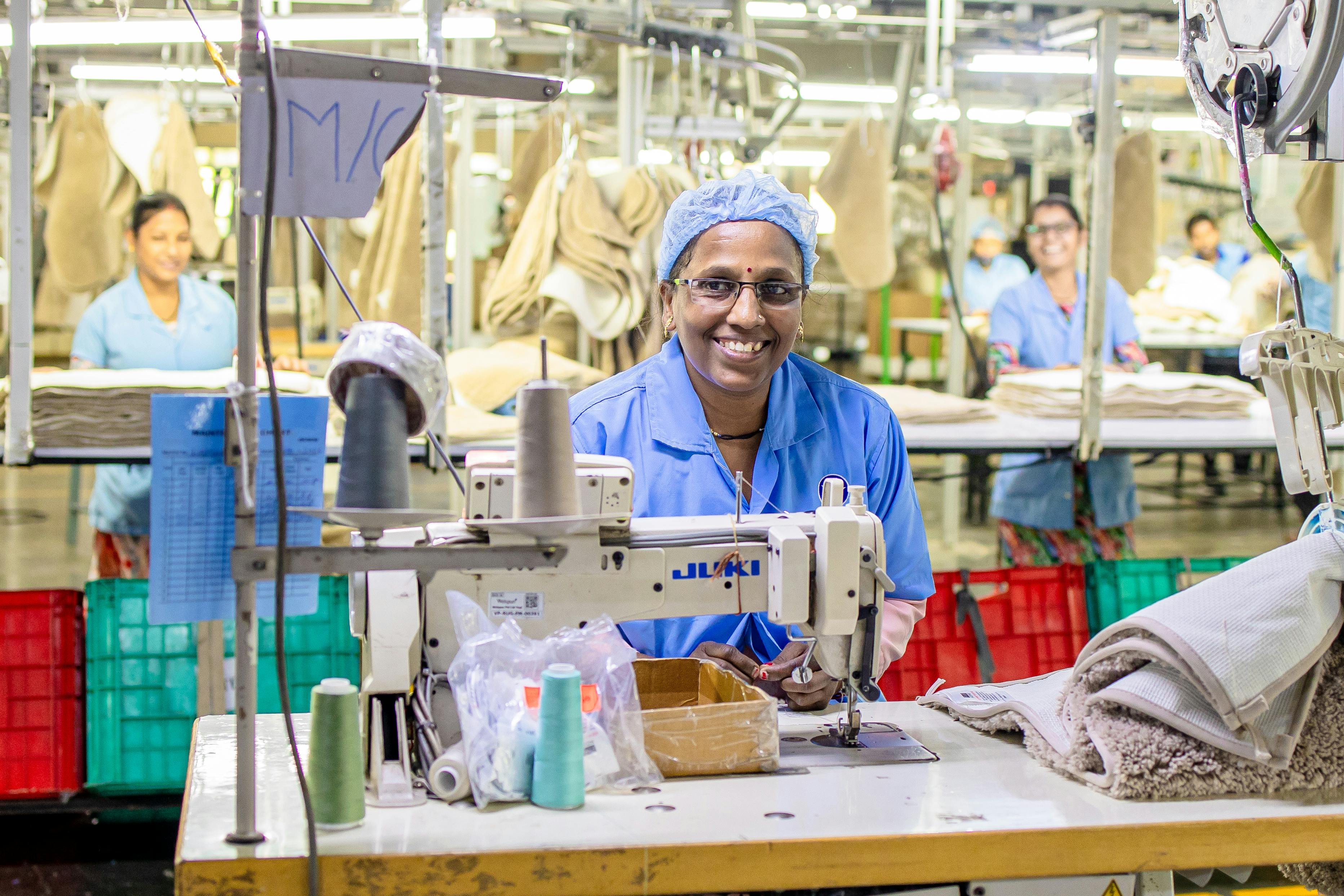 Smiling Textile Worker Operating Sewing Machine in Factory · Free Stock ...