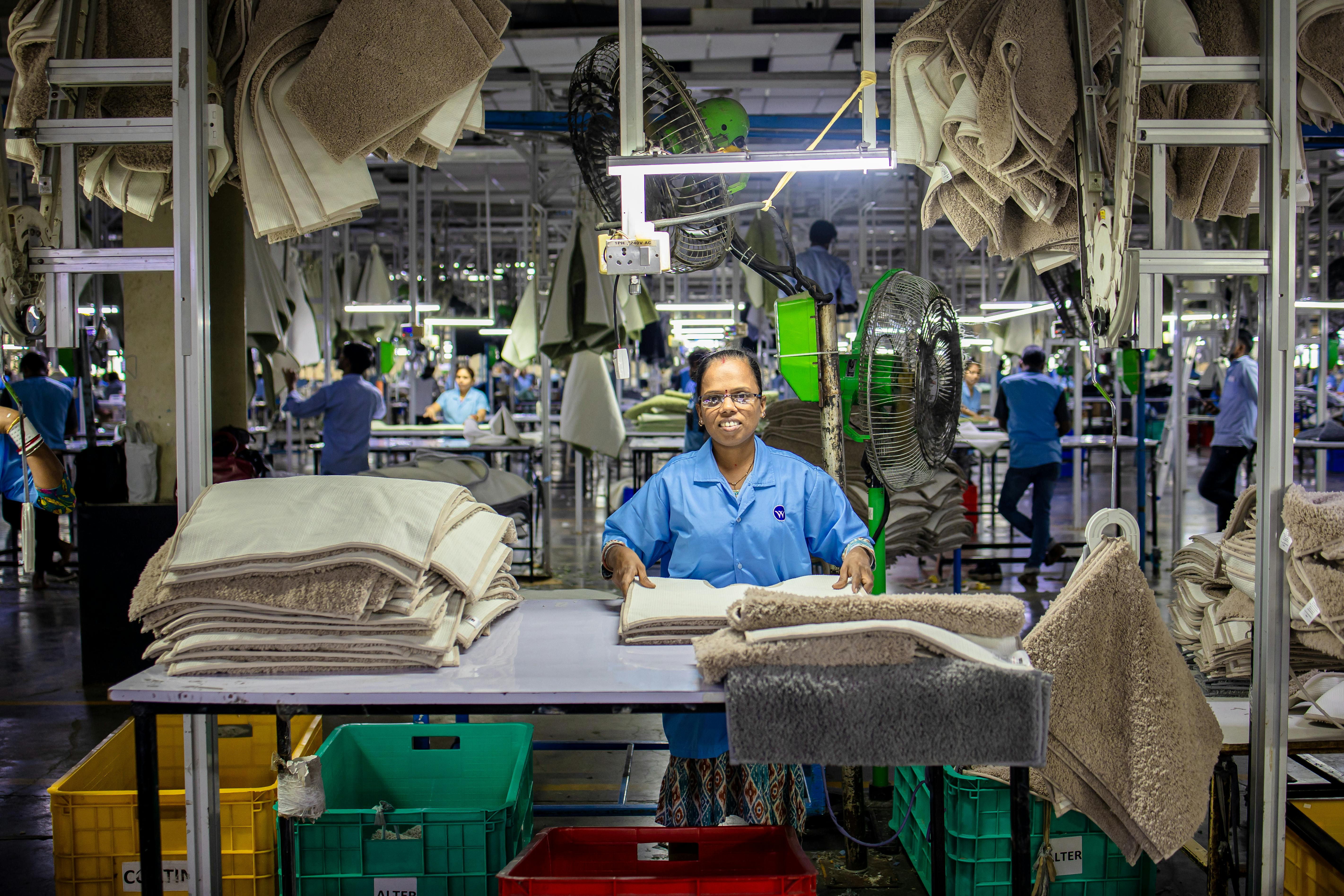 Indoors Textile Factory Worker Smiling at Table · Free Stock Photo