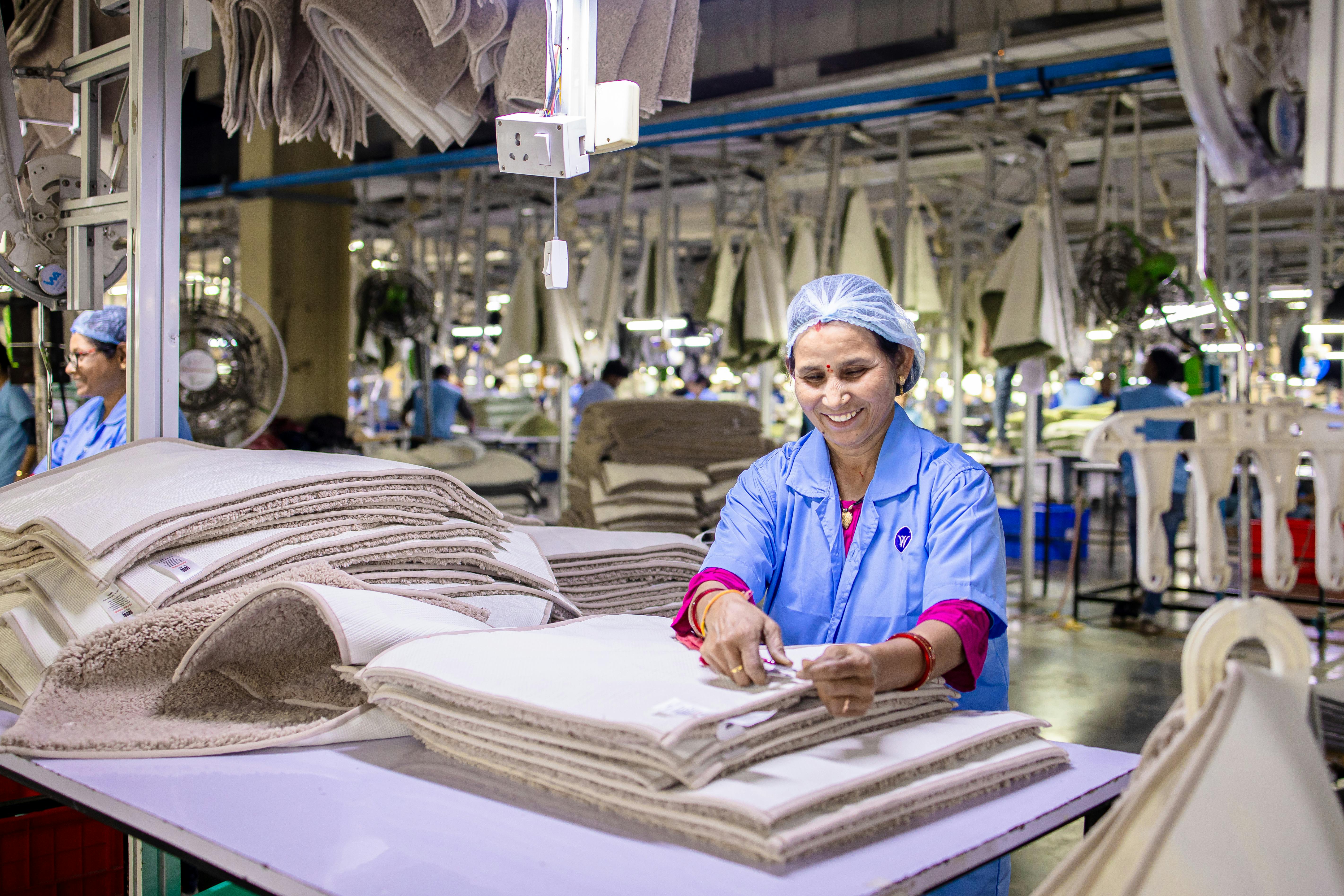 Smiling Textile Worker in Modern Factory Setting · Free Stock Photo