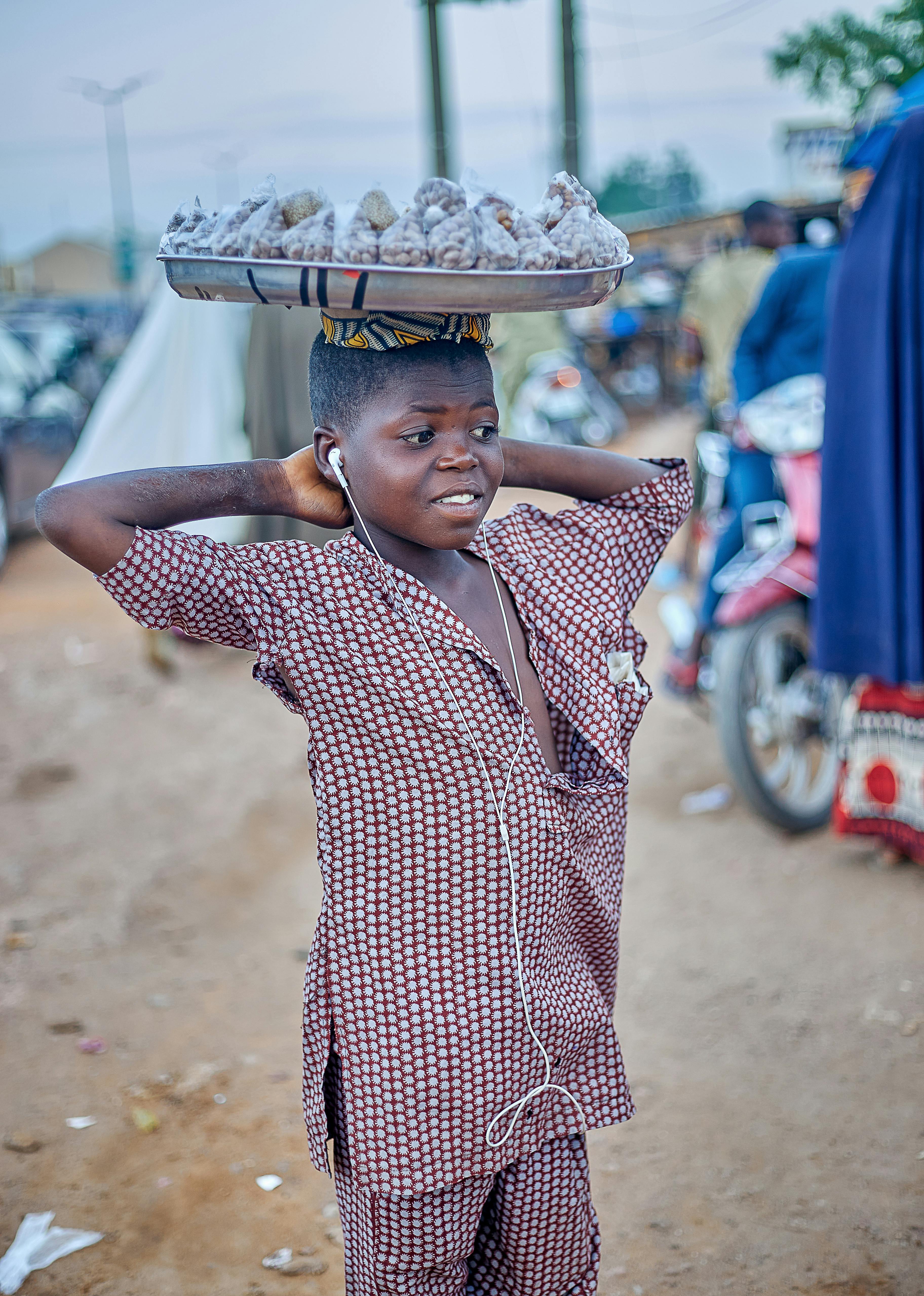 Young Street Vendor Balancing Tray in Busy Market · Free Stock Photo