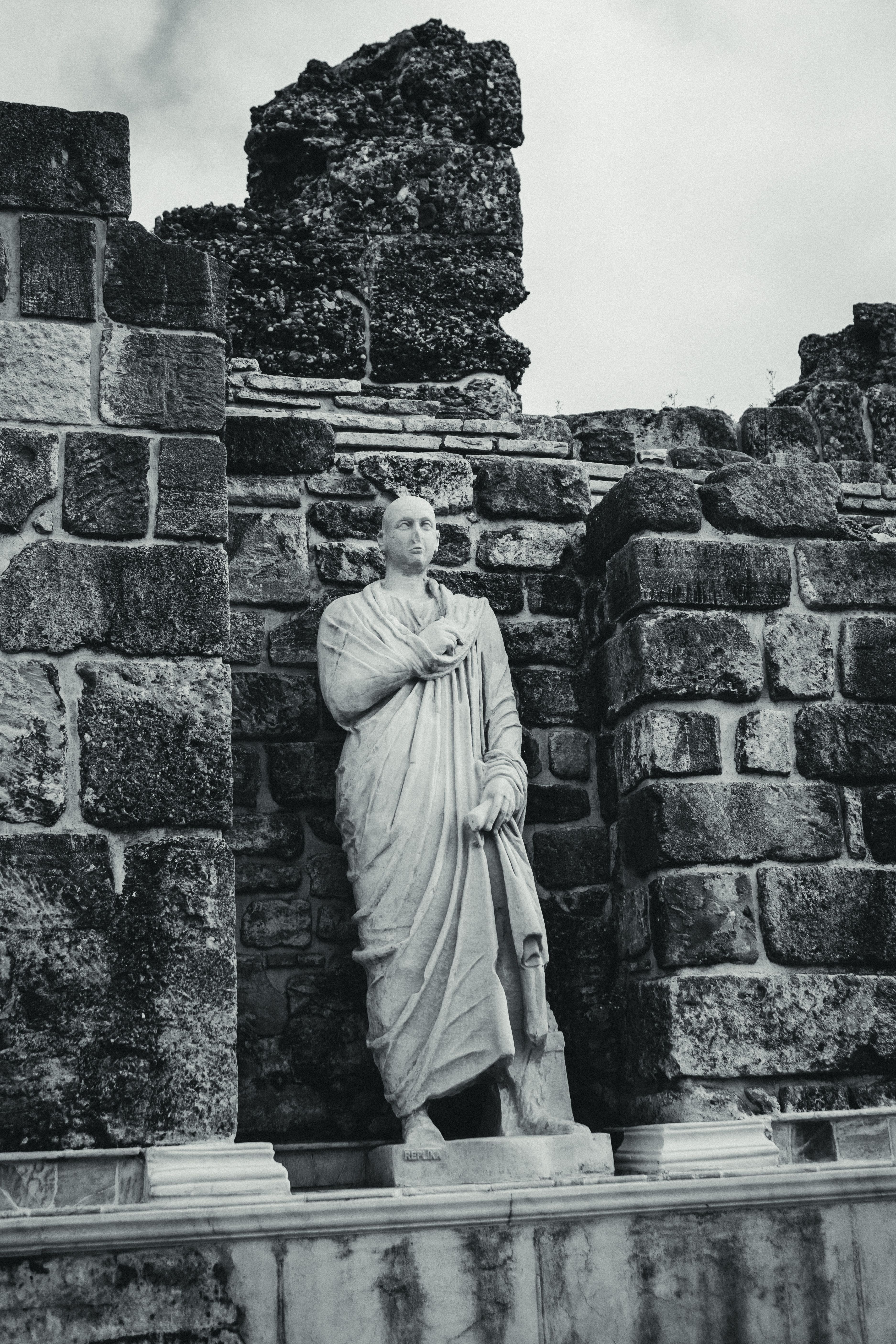 Ancient Roman Statue amidst Ruins in Black and White · Free Stock Photo
