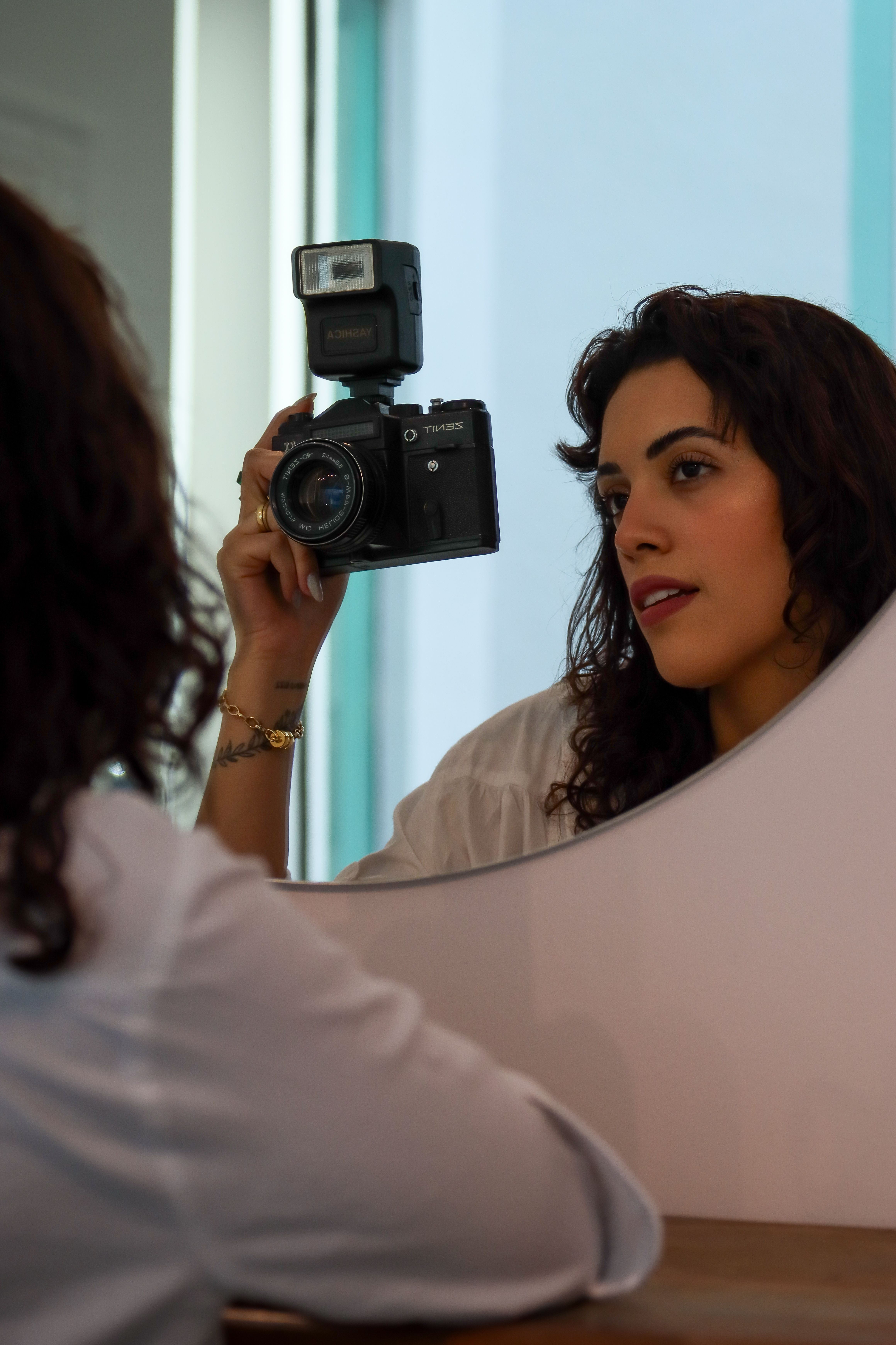 Woman Photographing Mirror Reflection in Bright Room · Free Stock Photo