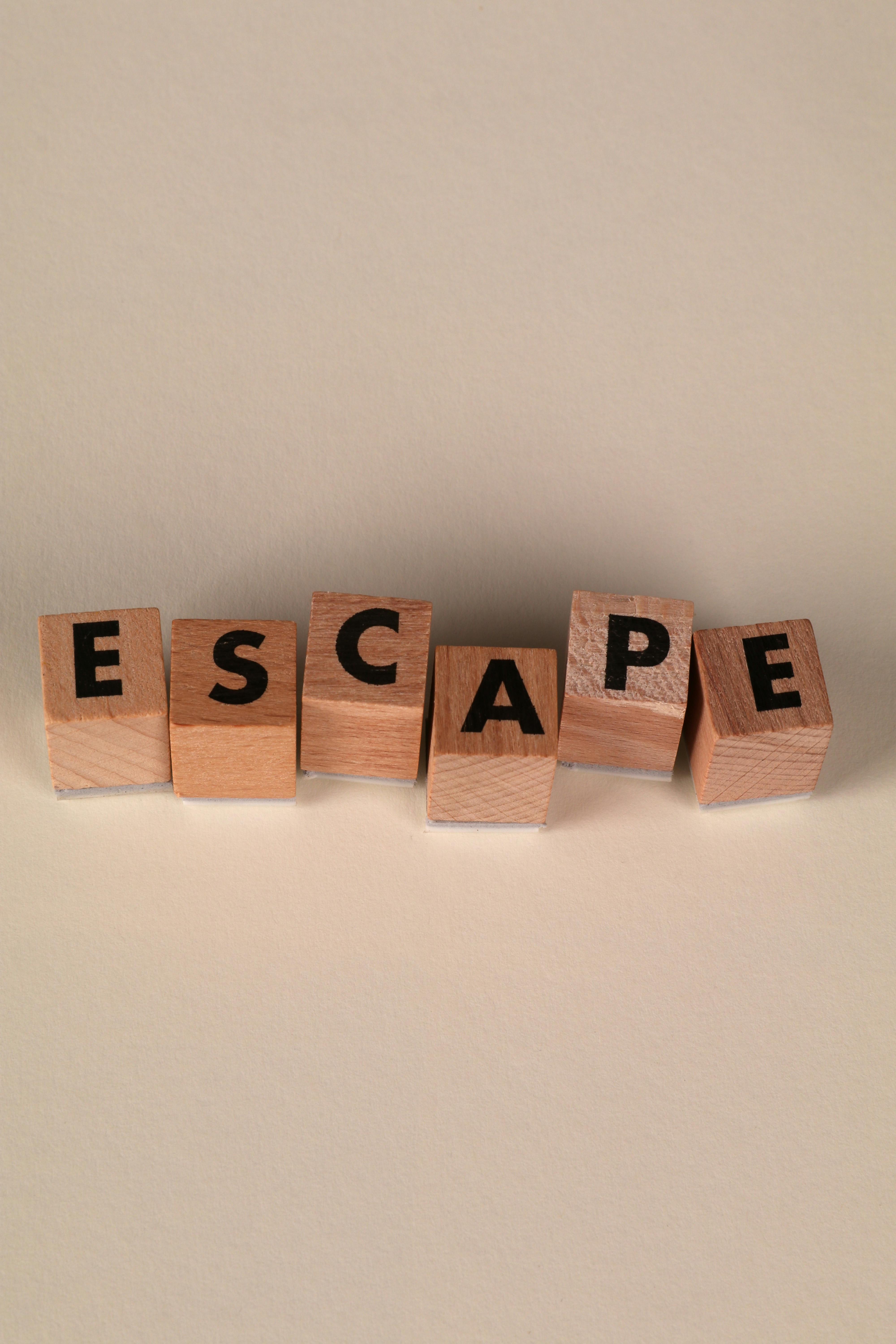 Wooden Blocks Spelling Escape on Neutral Background · Free Stock Photo