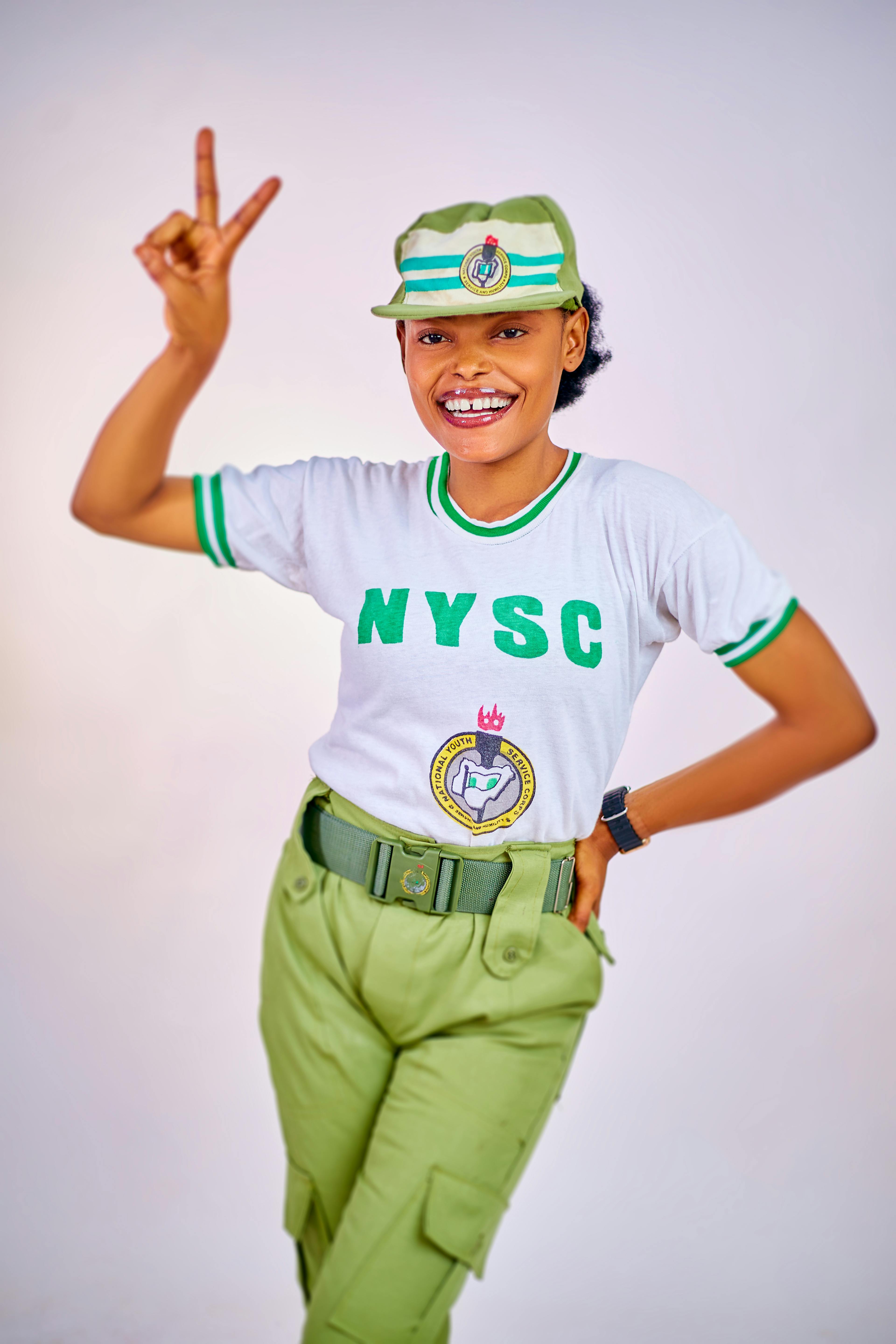 NYSC Member in Uniform Raising a Peace Sign · Free Stock Photo