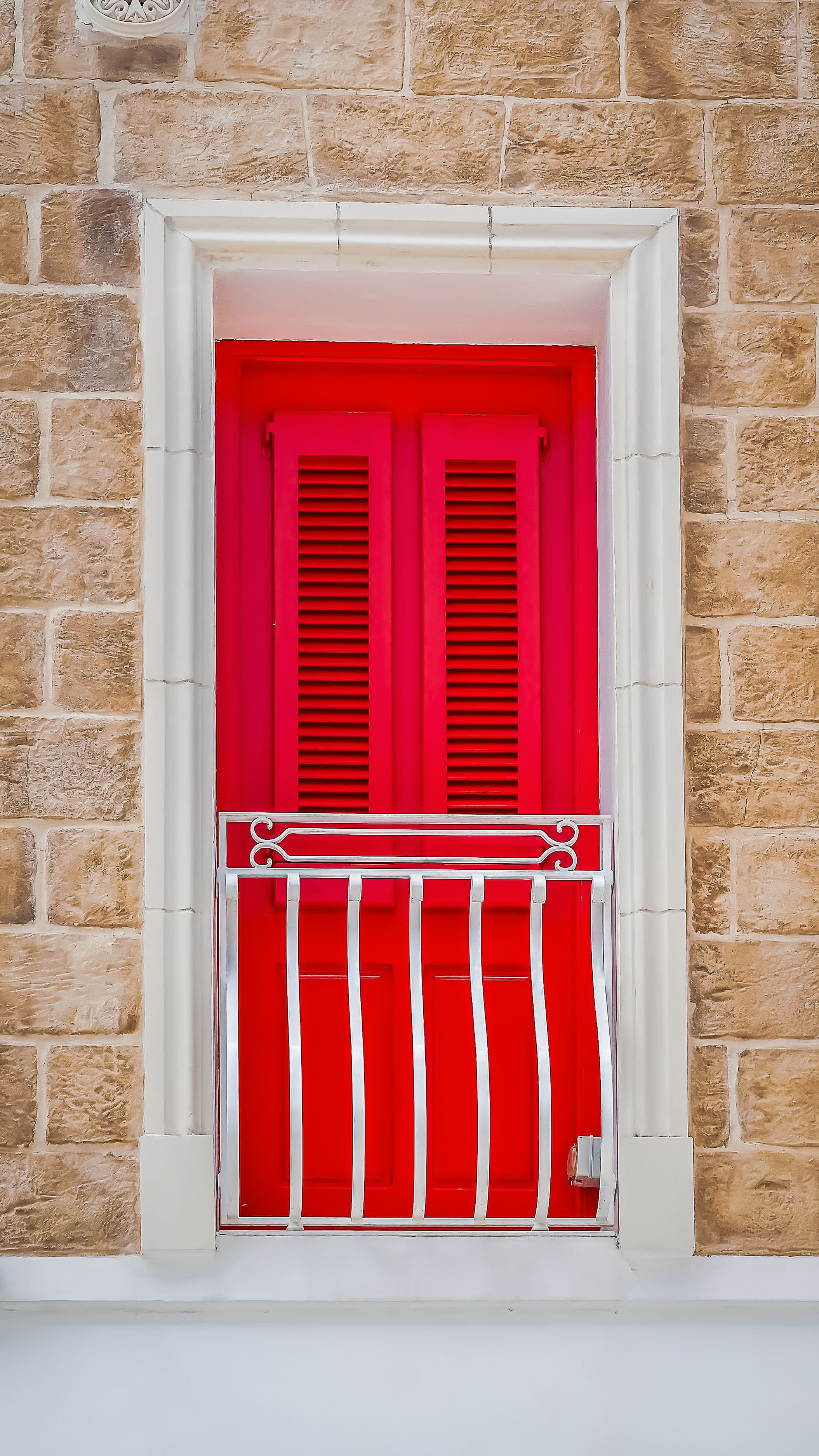 Bright Red Door with Decorative Ironwork in Stone Wall · Free Stock Photo