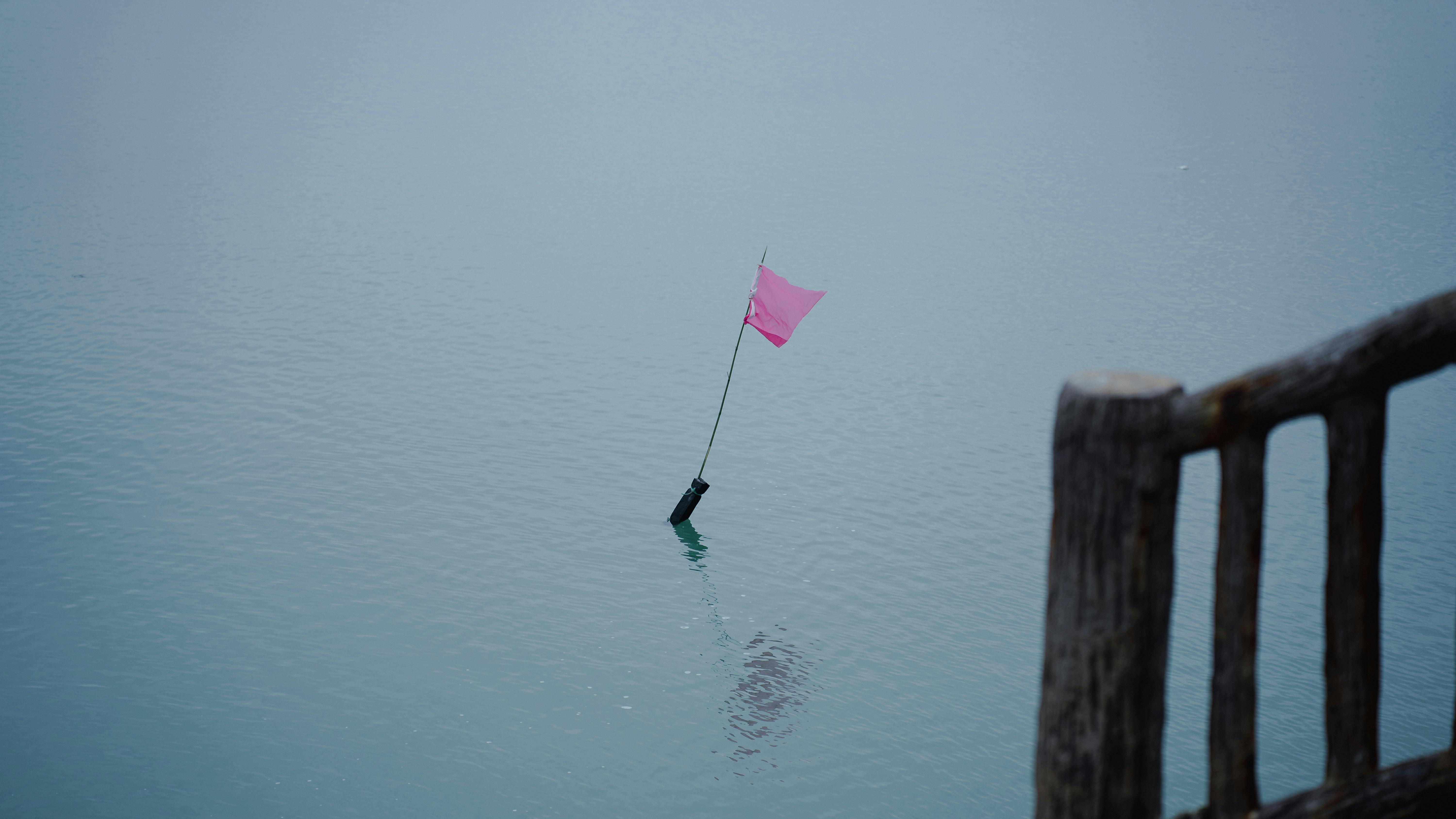 Pink Flag Marker Floating in Calm Water · Free Stock Photo