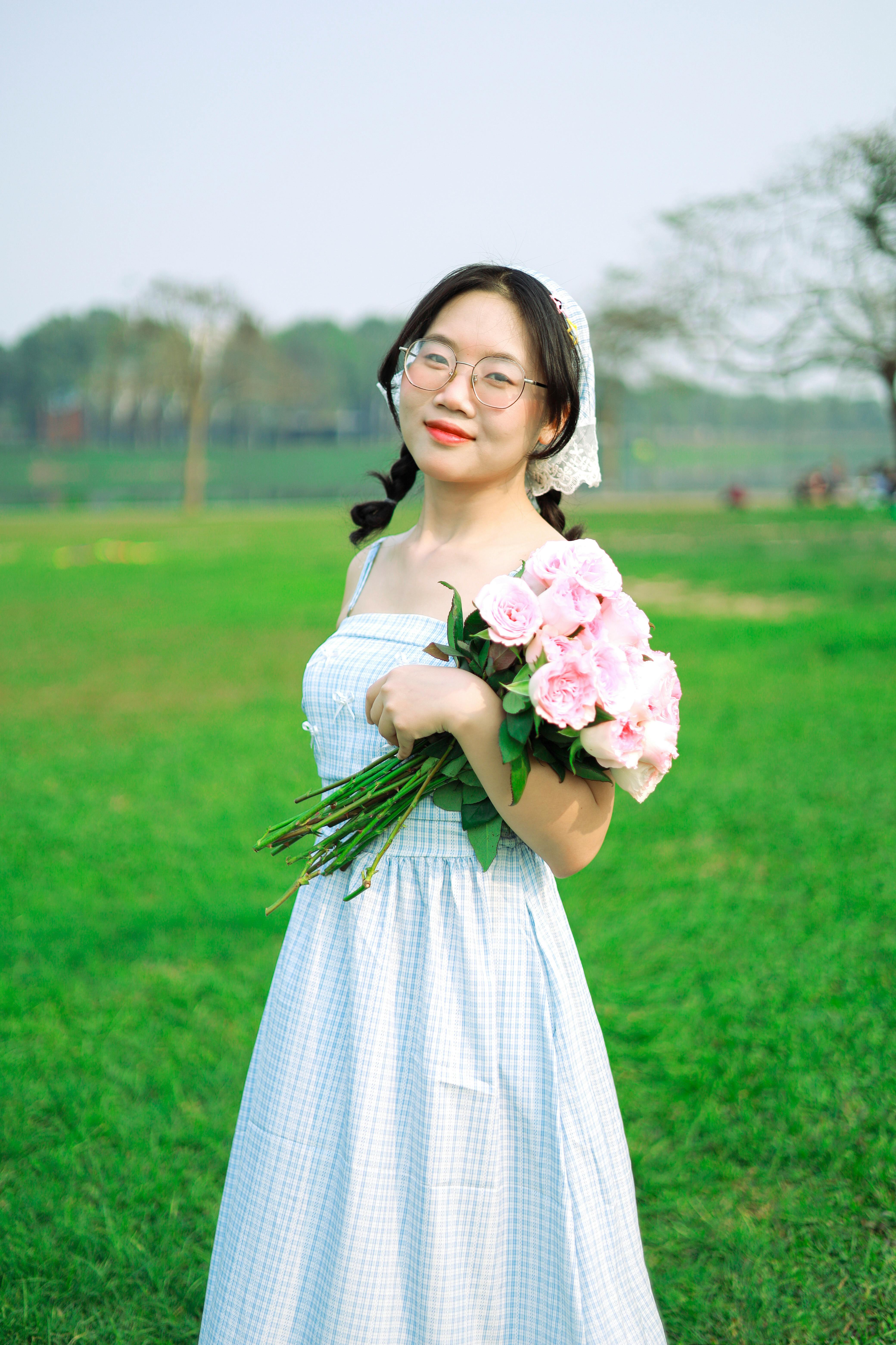 Young Woman Holding Pink Roses Outdoors · Free Stock Photo