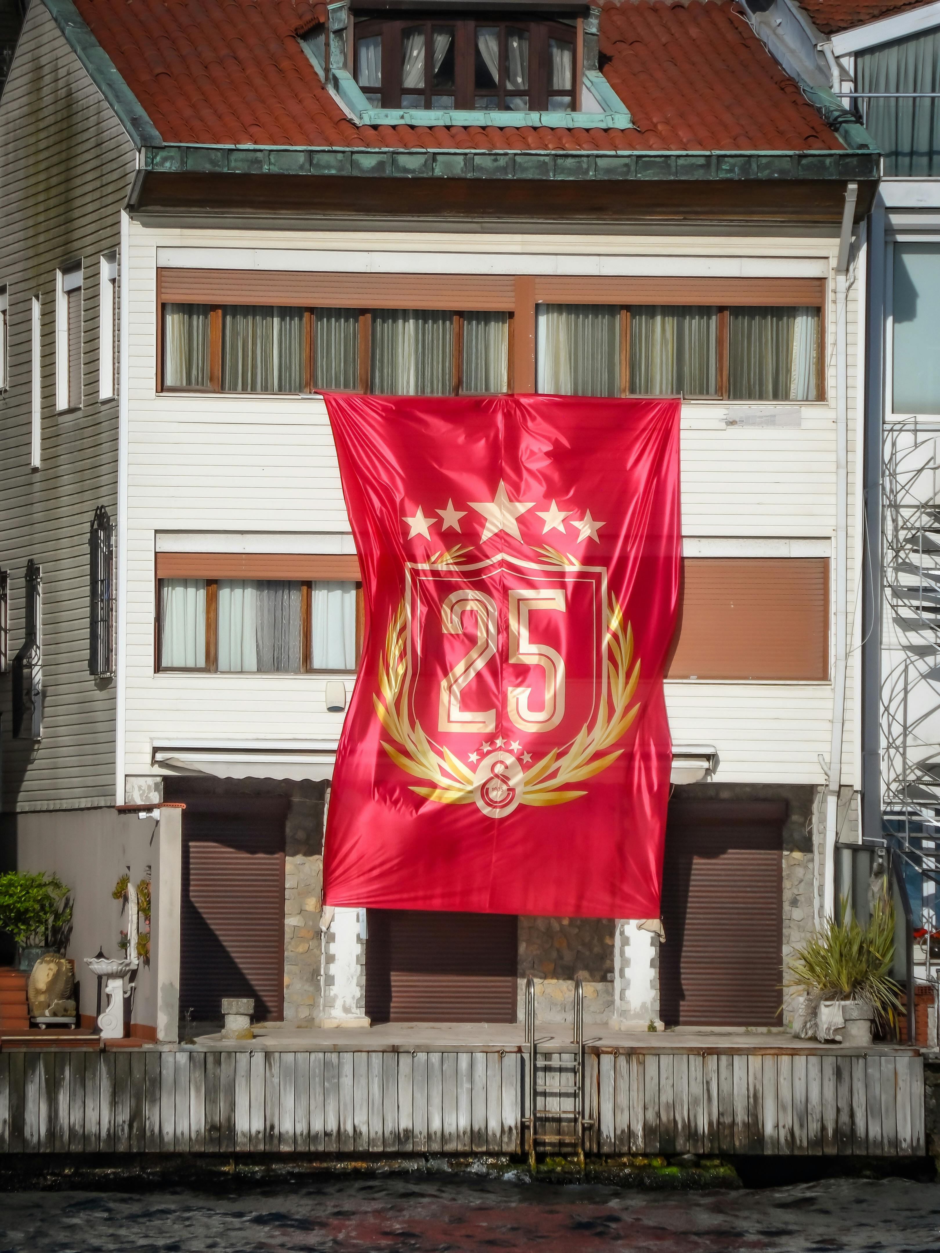 Building Displaying Large Red Banner with Number 25 · Free Stock Photo