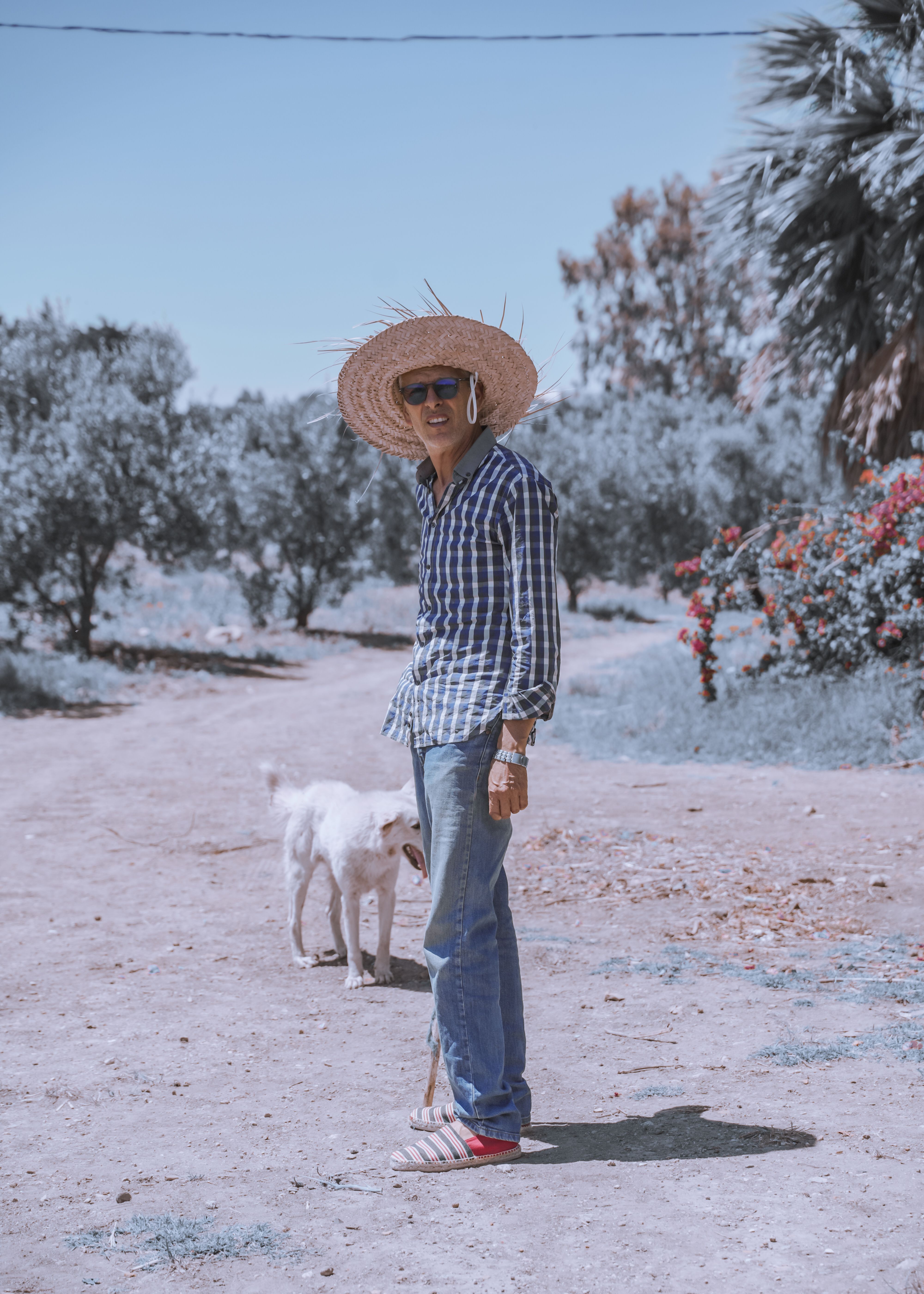 Woman in Straw Hat Stands on Farm Pathway in Summer · Free Stock Photo