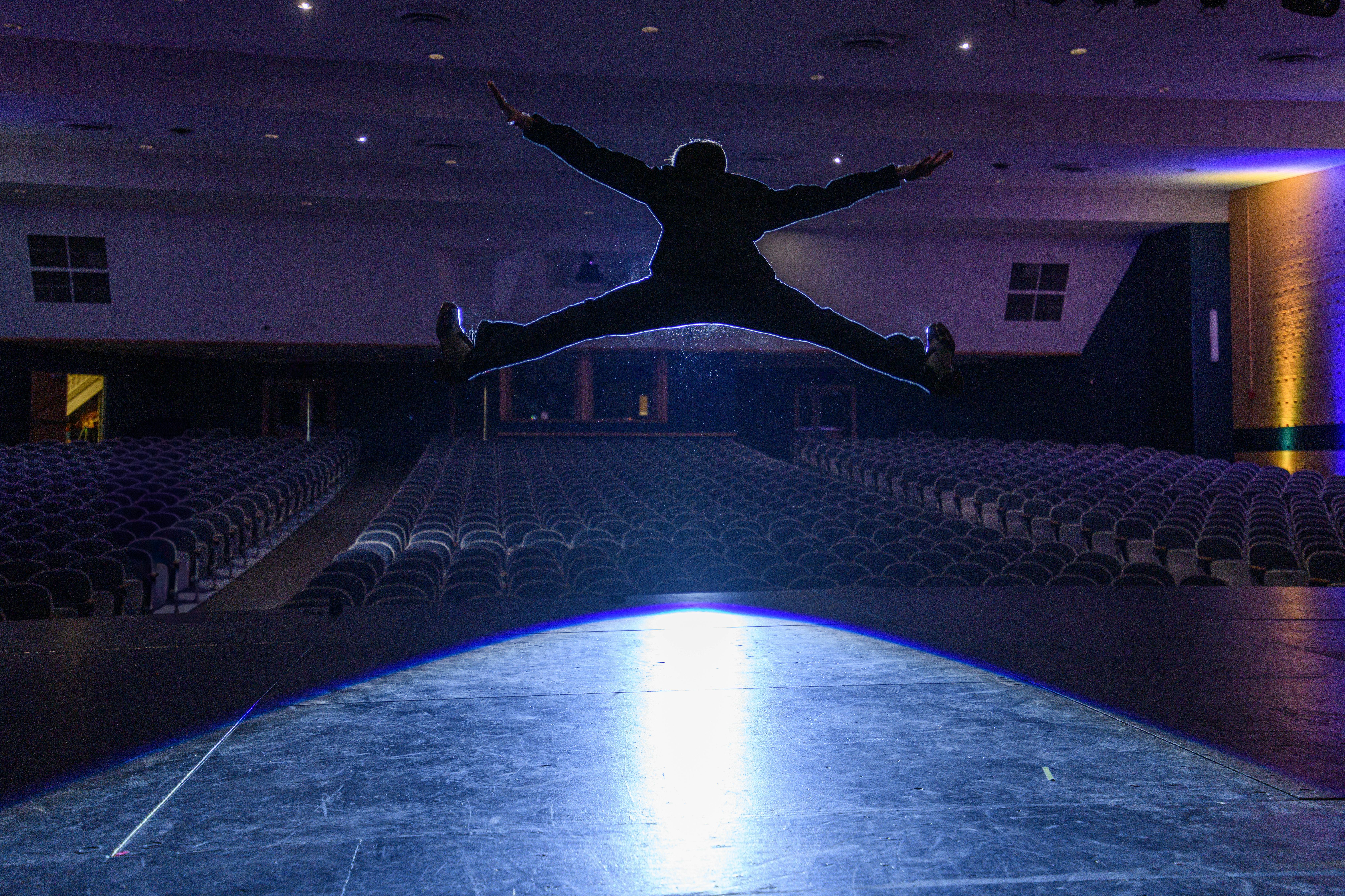 Dramatic Jump on Theater Stage with Spotlight · Free Stock Photo