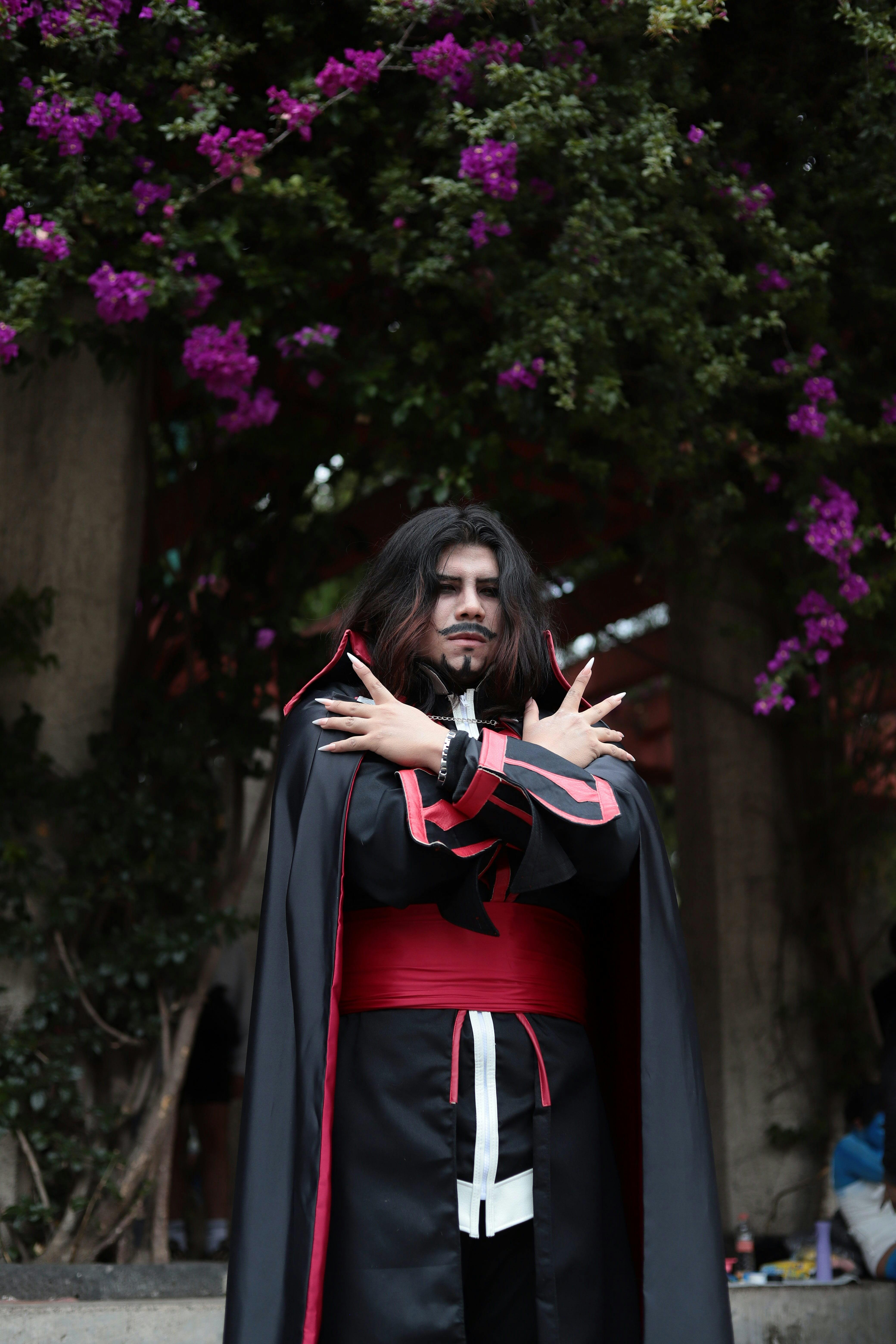 Cosplayer in Gothic Costume with Floral Backdrop · Free Stock Photo