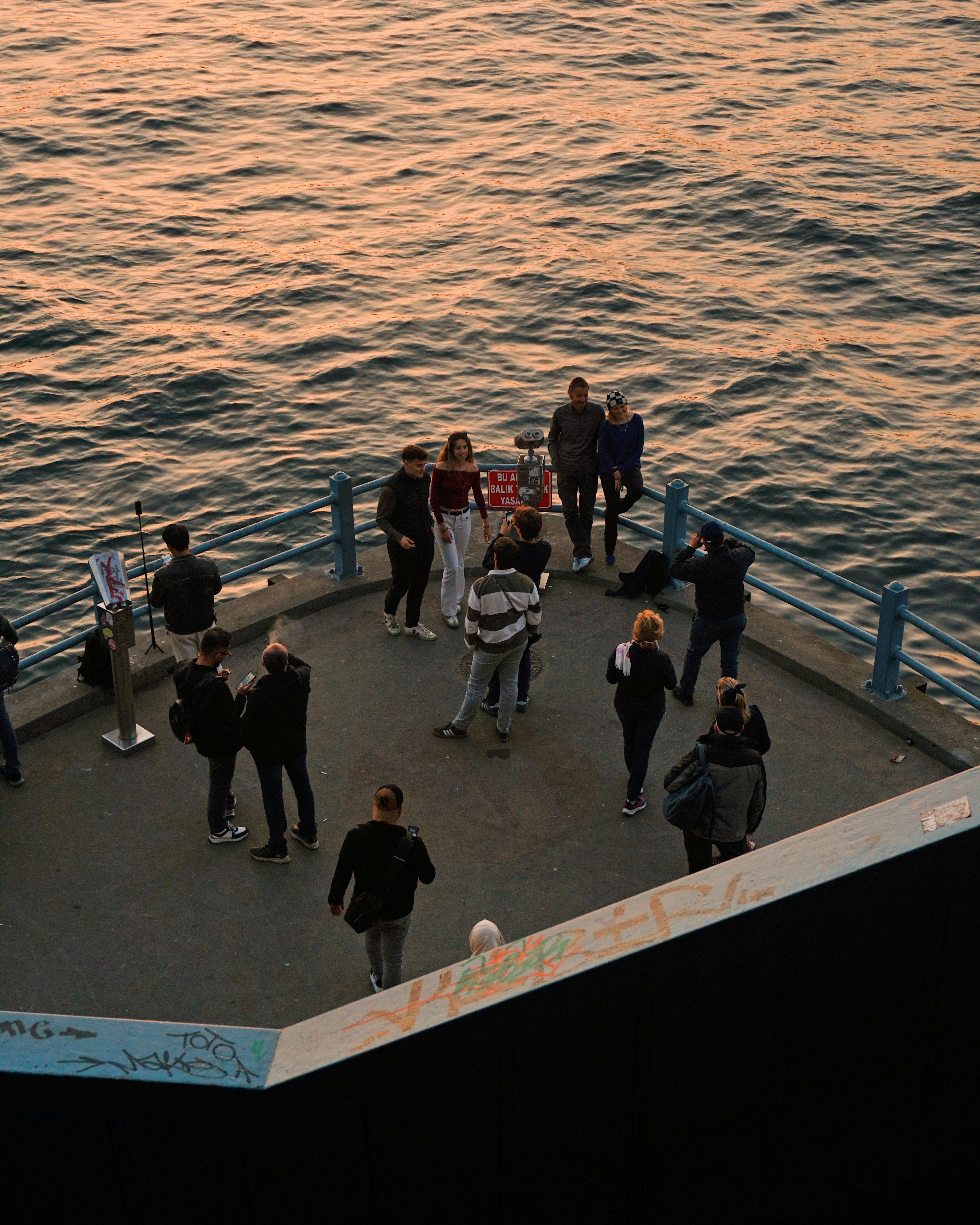 Sunset Gathering on Urban Waterfront Pier · Free Stock Photo