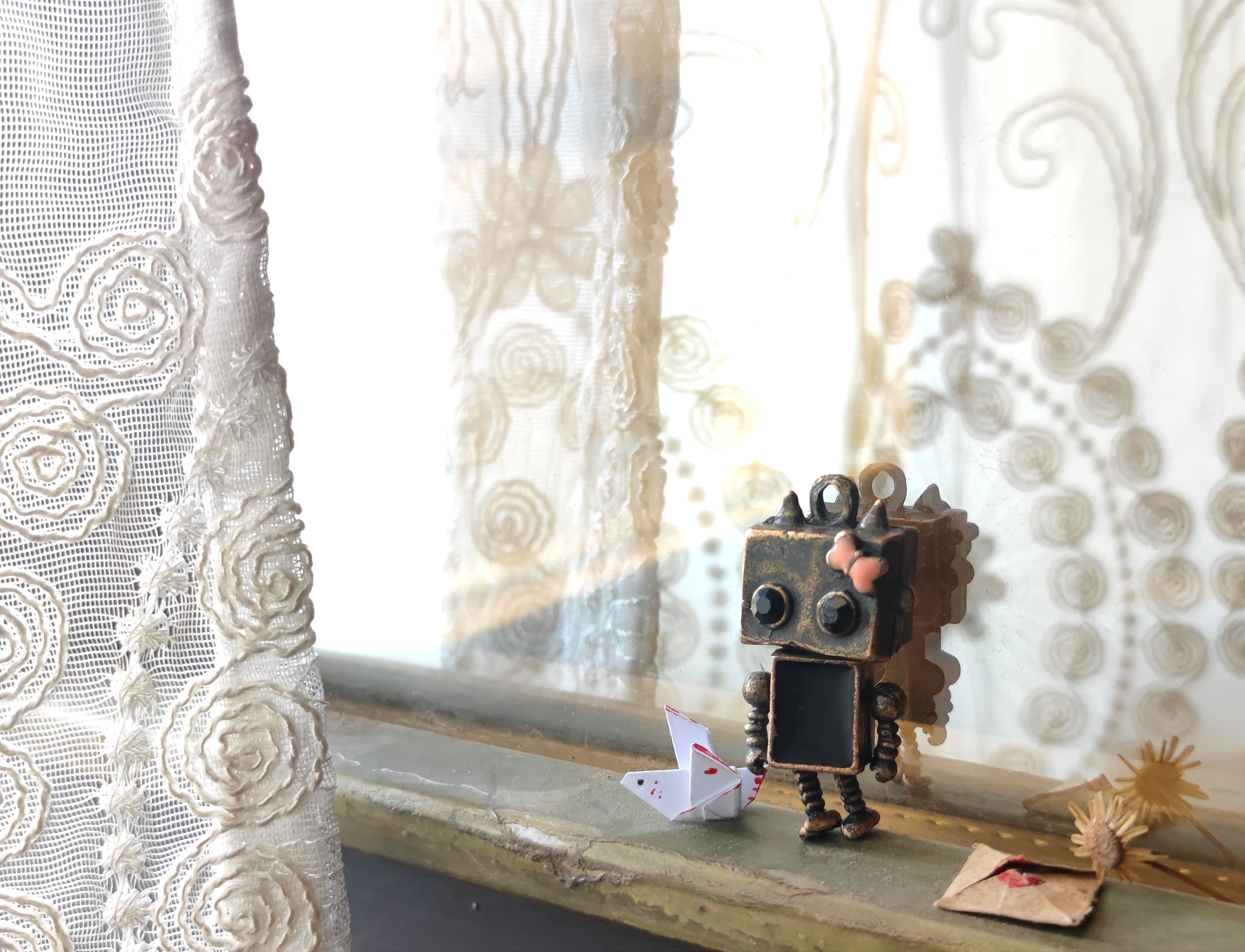 Cute Robot Figurine with Origami on Window Sill · Free Stock Photo