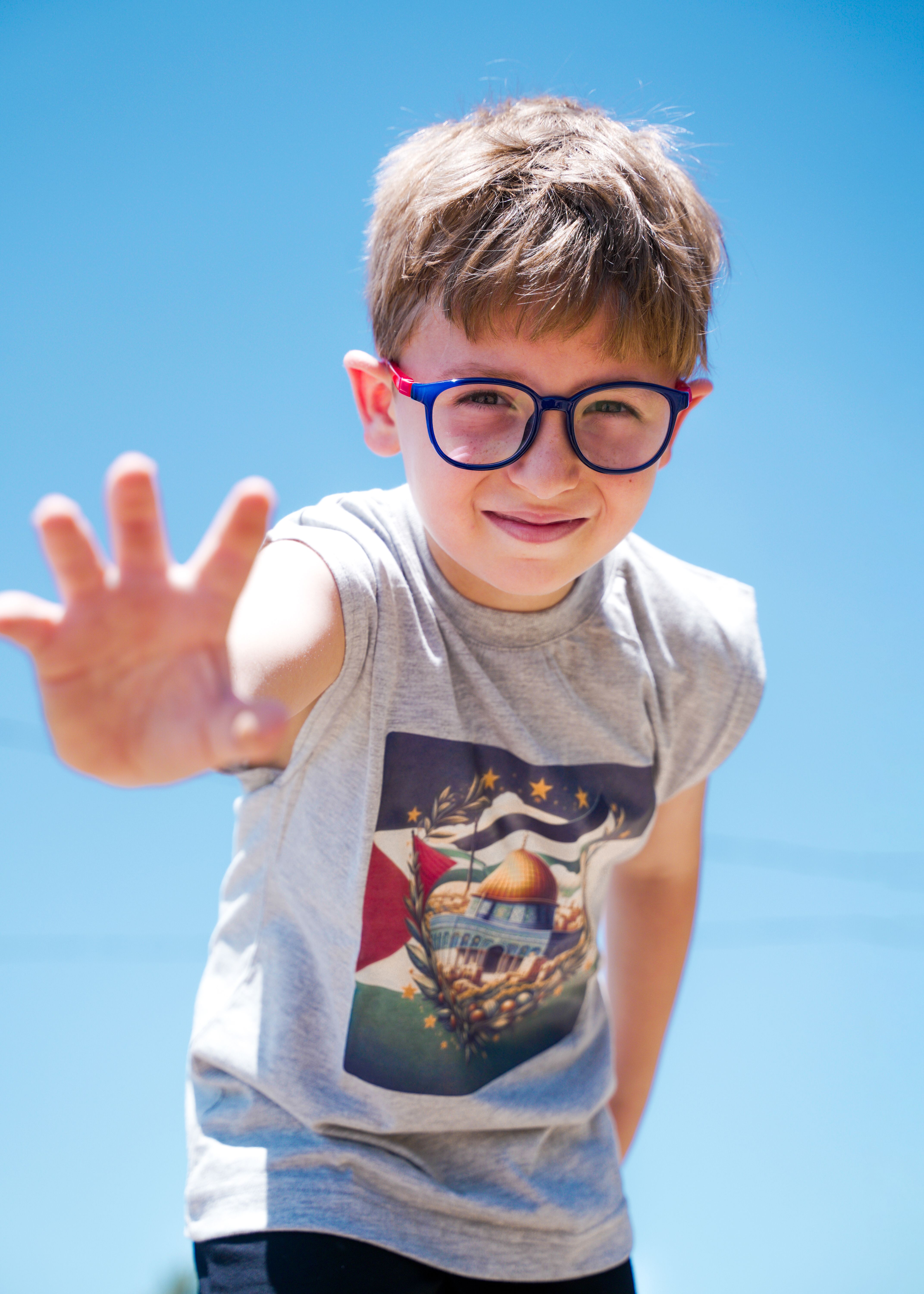 Smiling Child with Glasses Reaching Forward Outdoors · Free Stock Photo