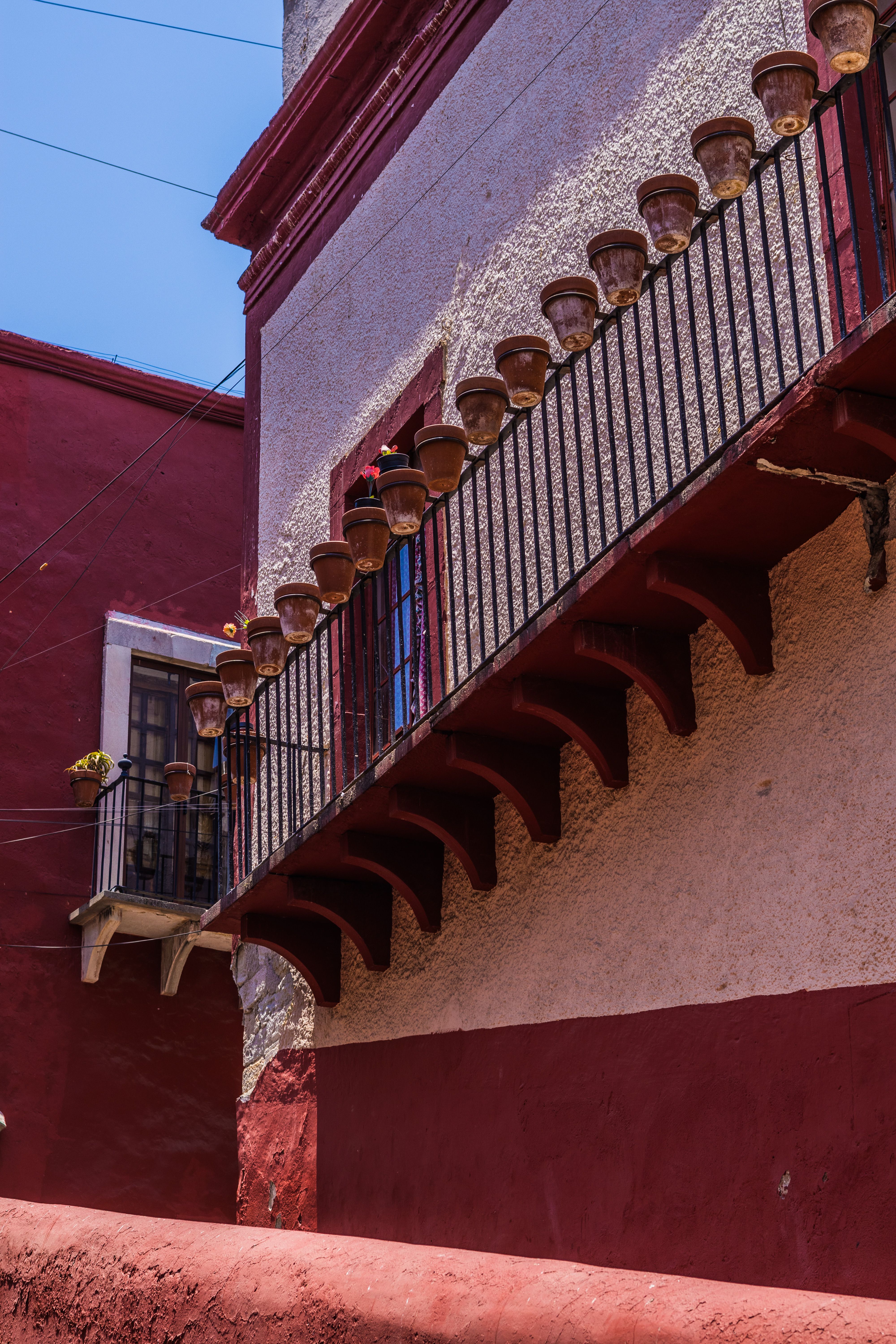 Charming Red Balcony with Flower Pots in Sunlight · Free Stock Photo