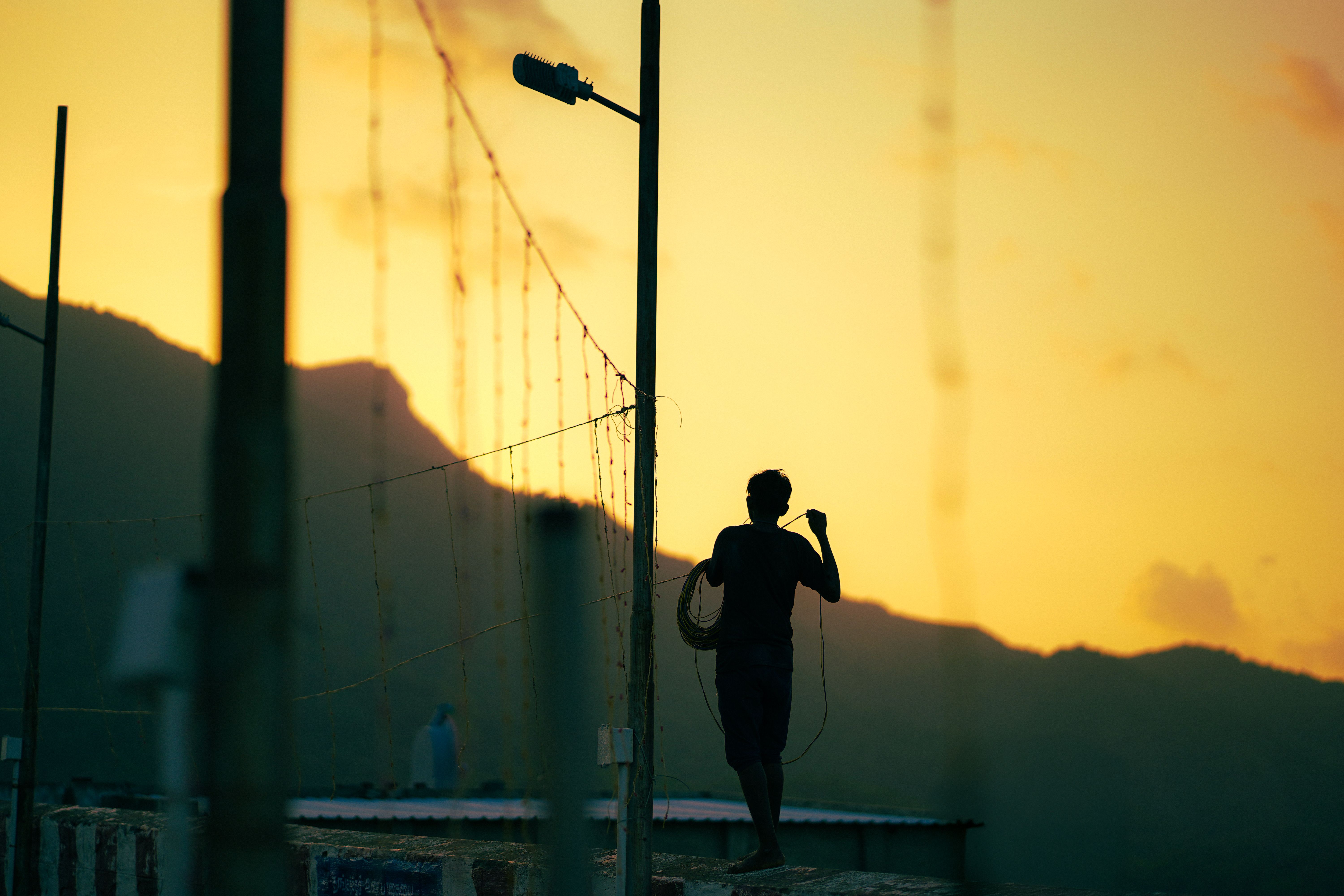 Silhouetted Figure at Sunset with Mountains · Free Stock Photo