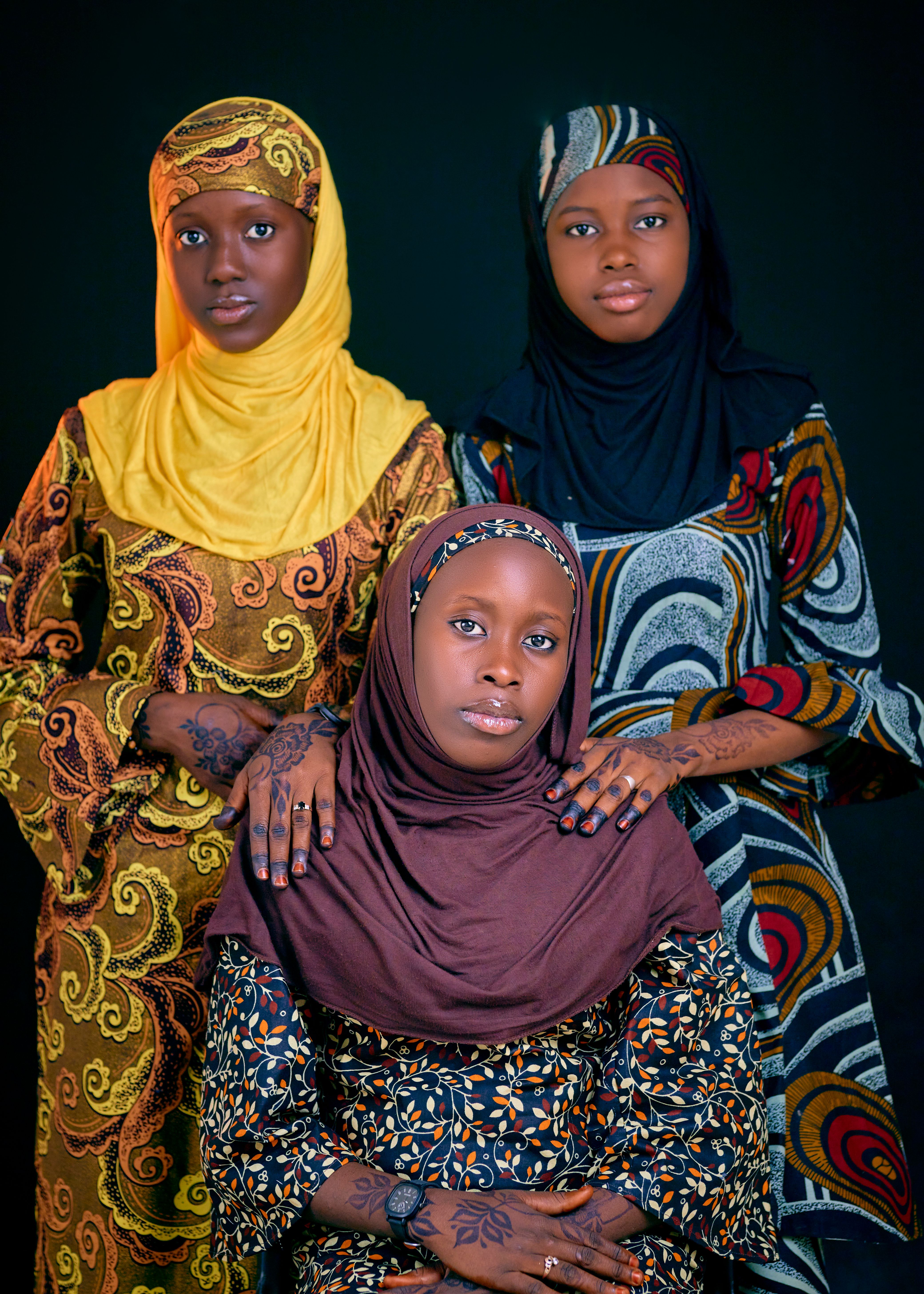 Three Women Embracing in Traditional Attire · Free Stock Photo