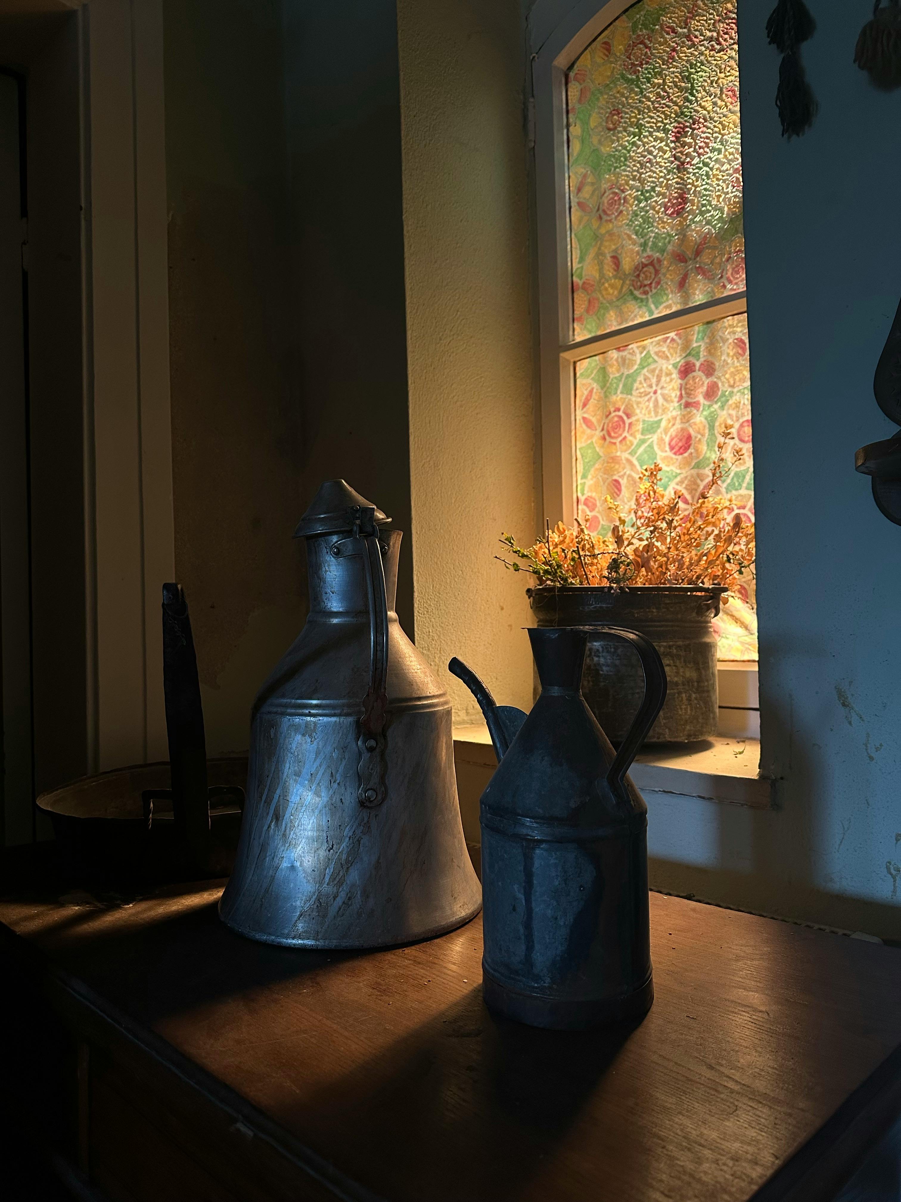 Vintage Oil Cans by a Stained Glass Window · Free Stock Photo