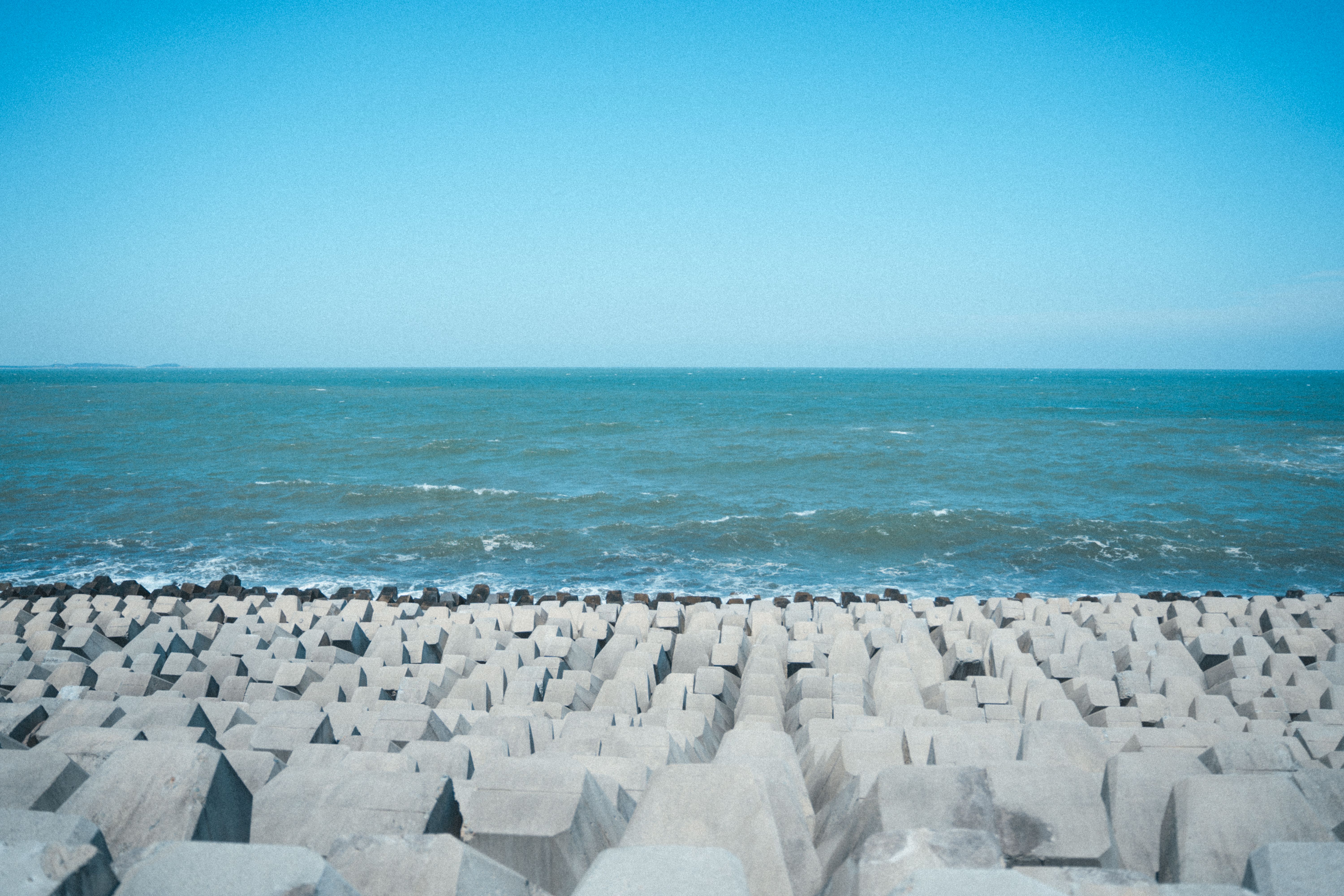 Concrete Blocks Against Ocean Waves at Coastline · Free Stock Photo
