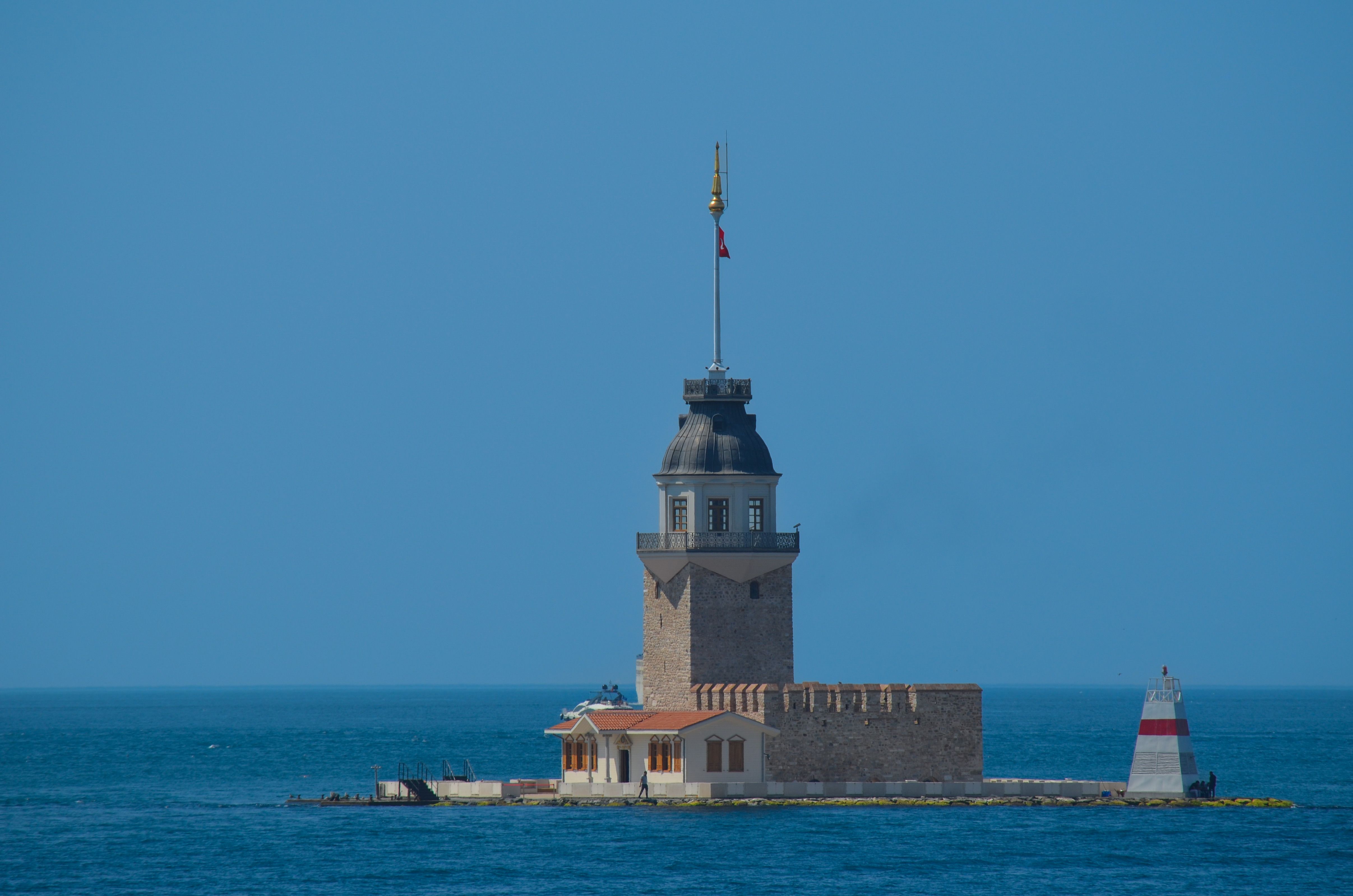 White Lighthouse Tower Beside Concrete Buildings · Free Stock Photo