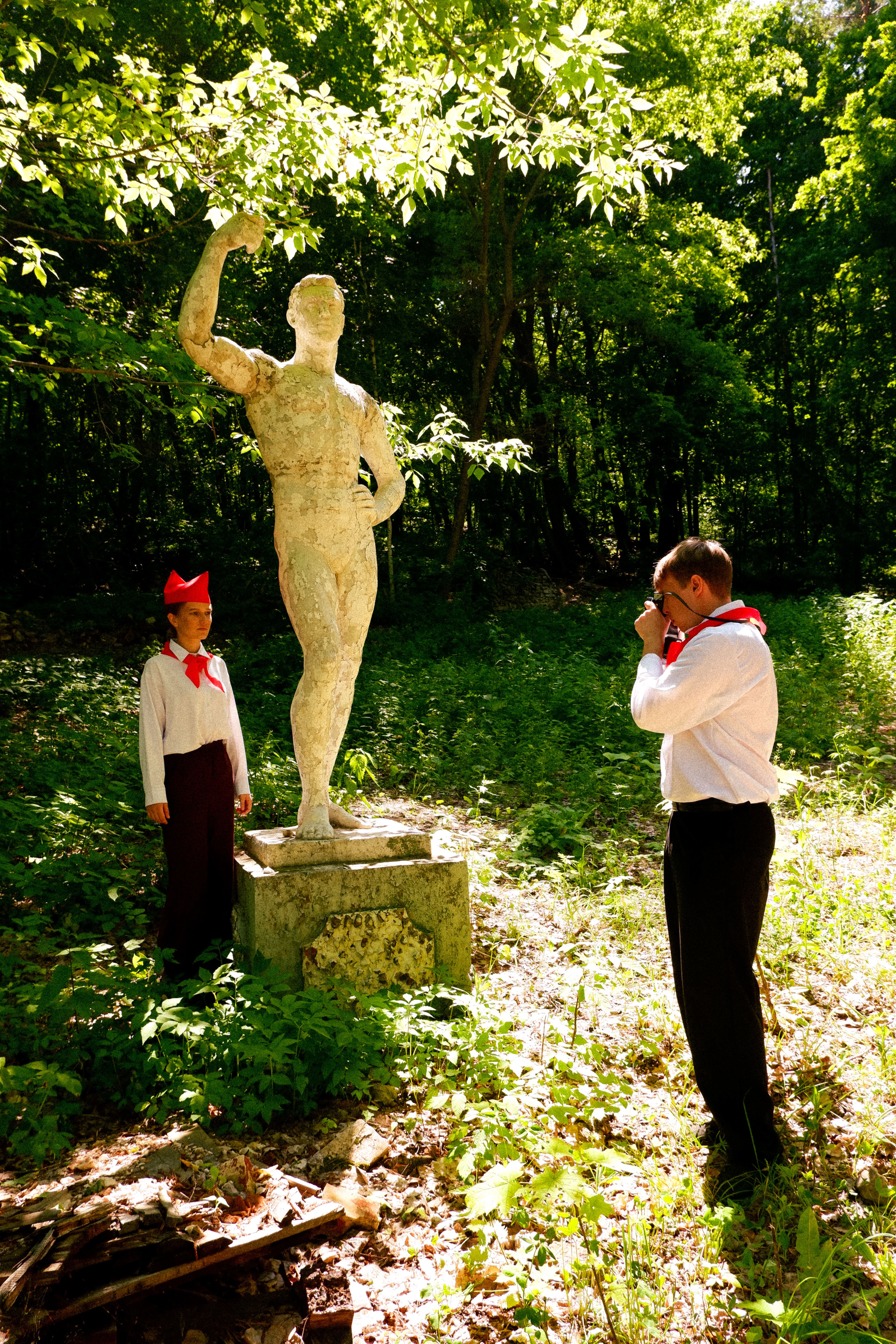 Photographer with Statue in Sunlit Forest · Free Stock Photo