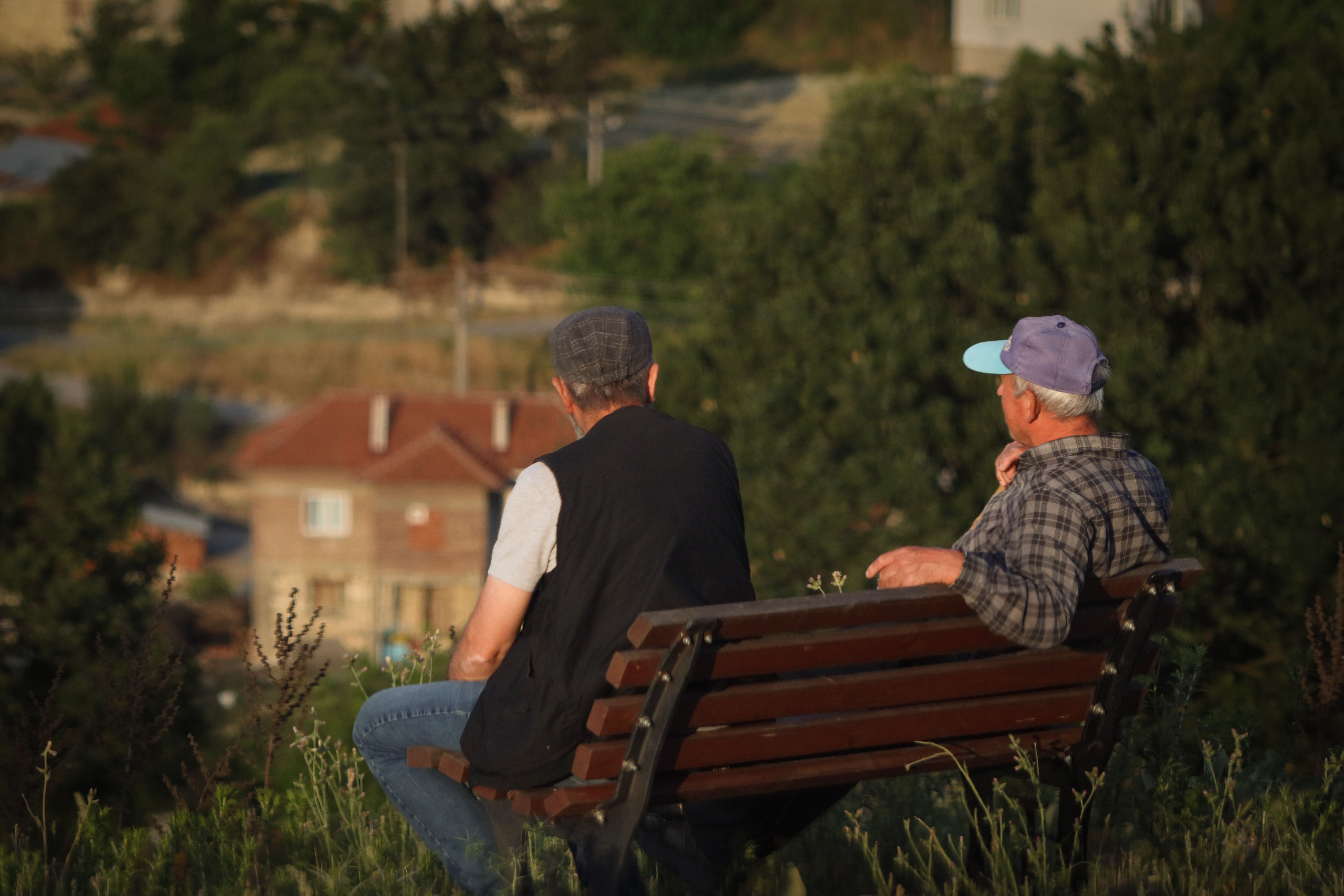 Two Men Sitting on Park Bench Outdoors · Free Stock Photo
