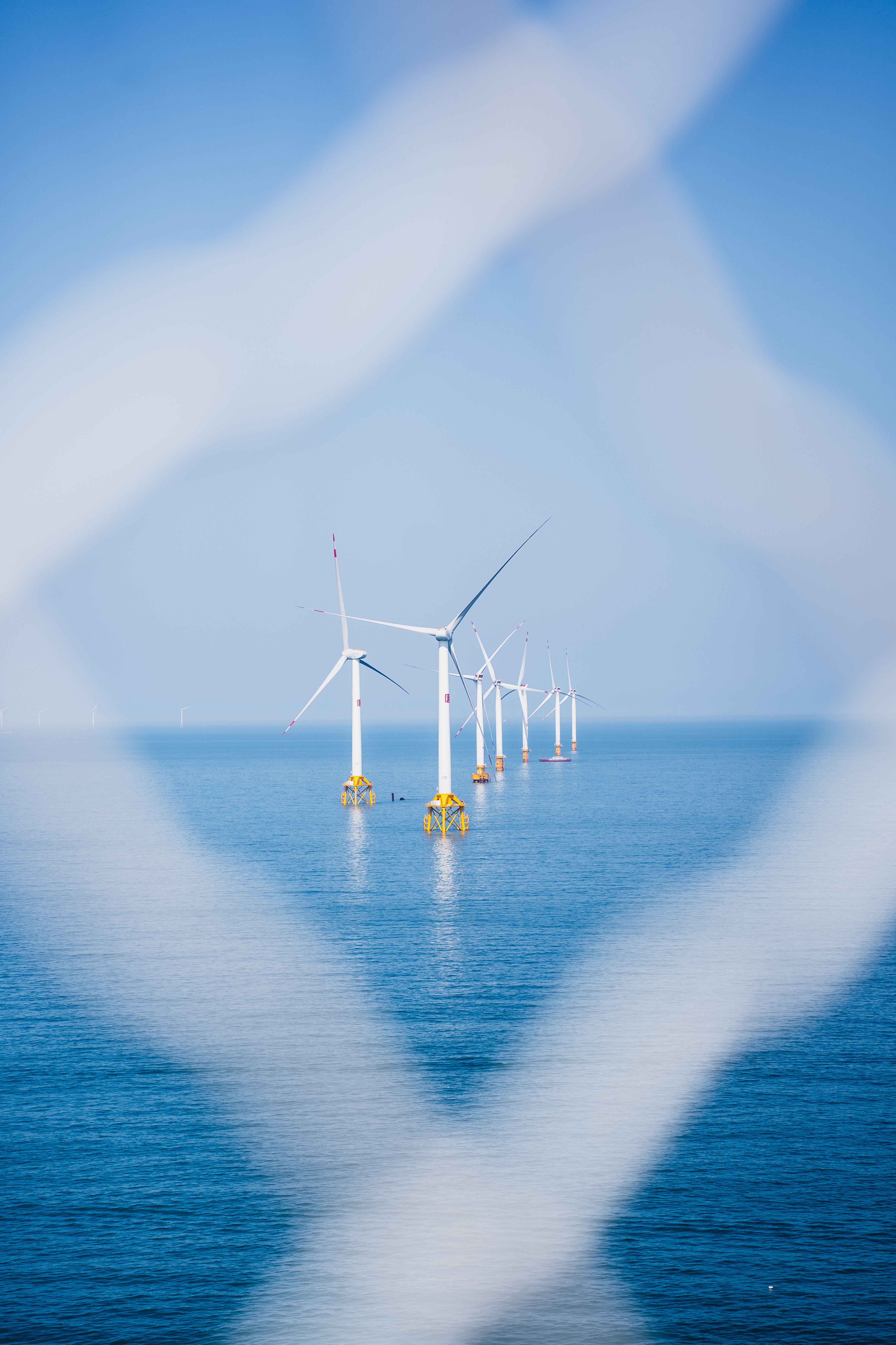 Offshore wind turbines in a serene blue sea · Free Stock Photo
