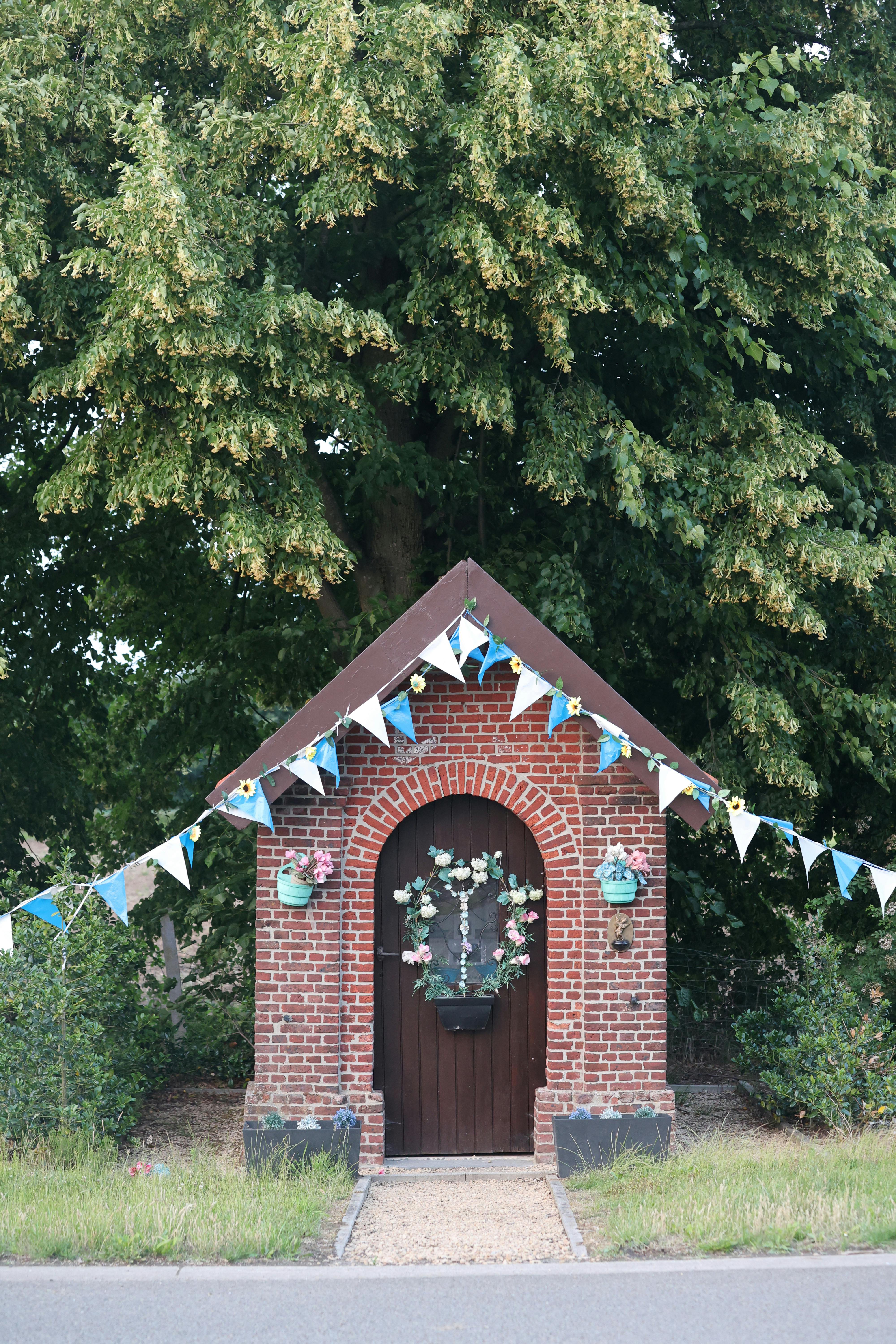 Charming Brick Chapel Adorned with Decorative Bunting · Free Stock Photo