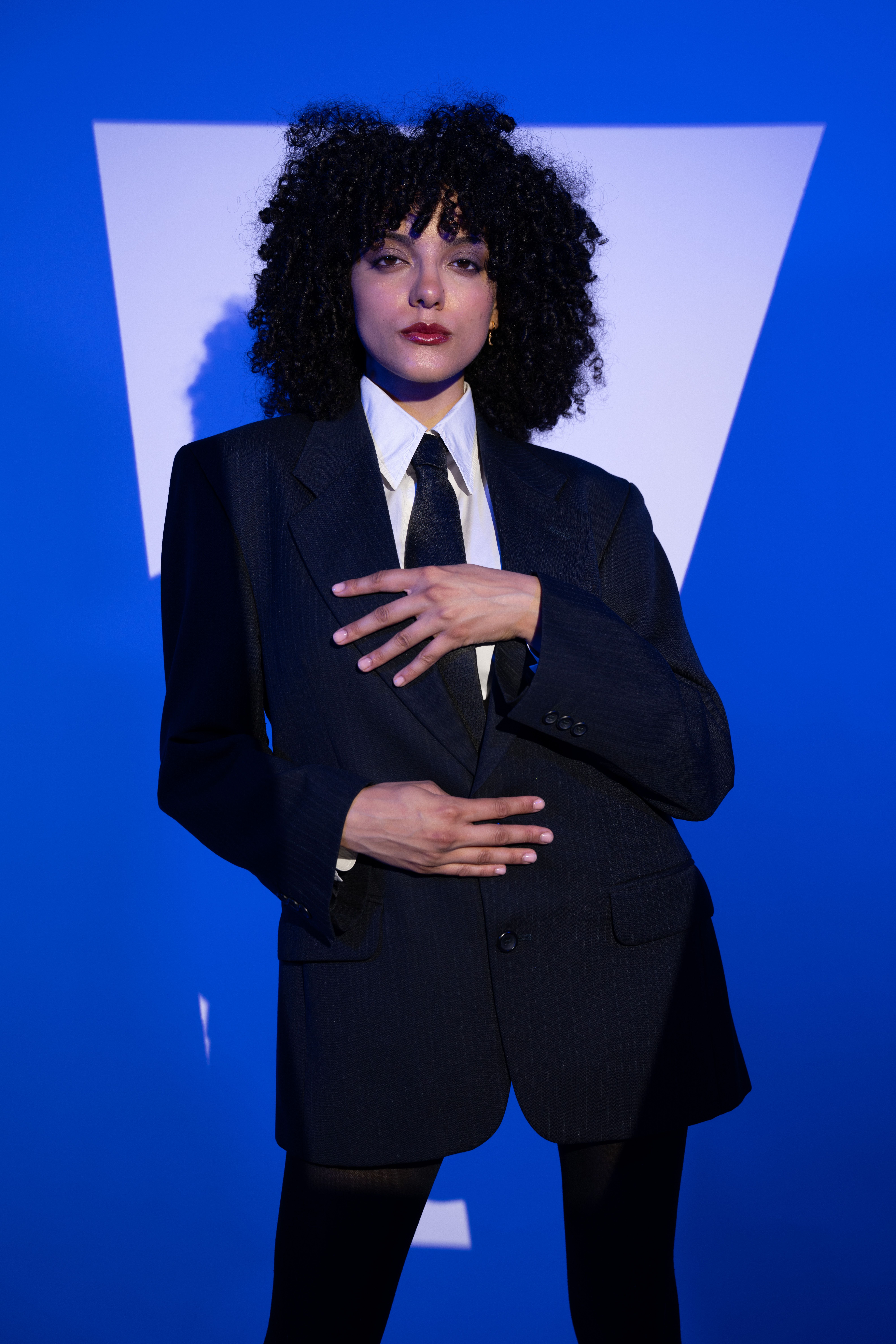 Elegant Female Model in Suit with Blue Background · Free Stock Photo