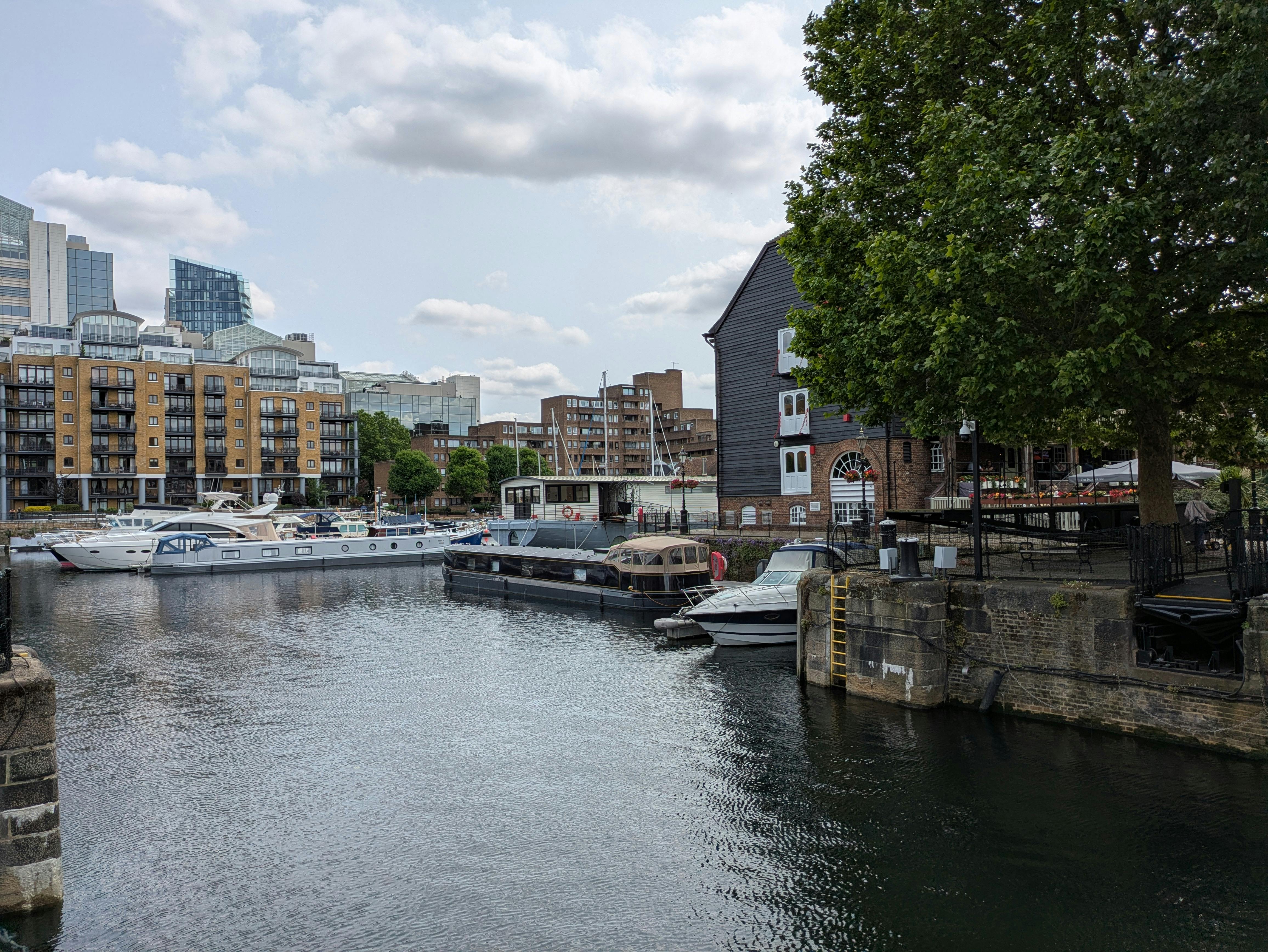 Scenic Urban Dock with Boats and Modern Architecture · Free Stock Photo