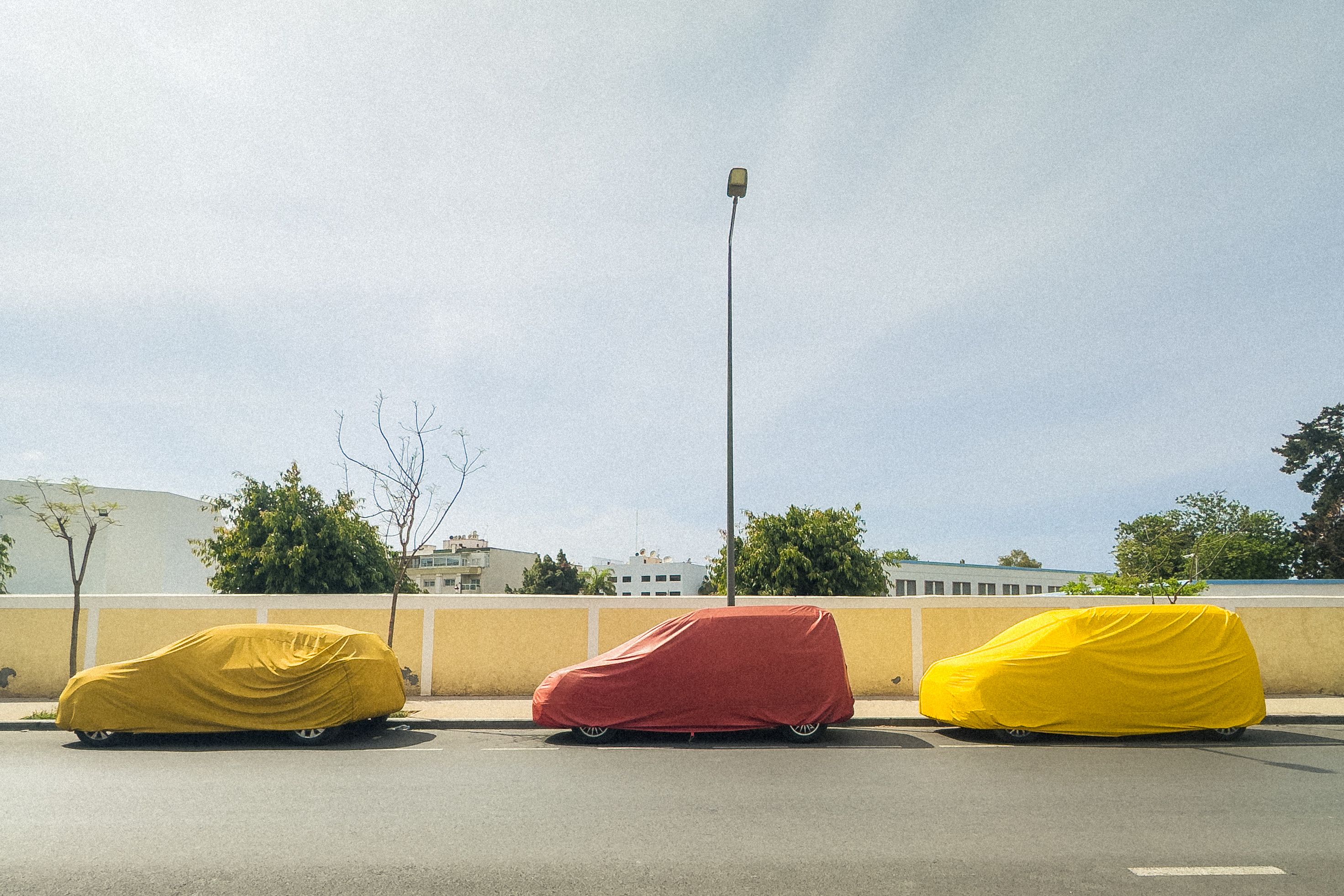 Colorful Covered Cars Lined Up on City Street · Free Stock Photo