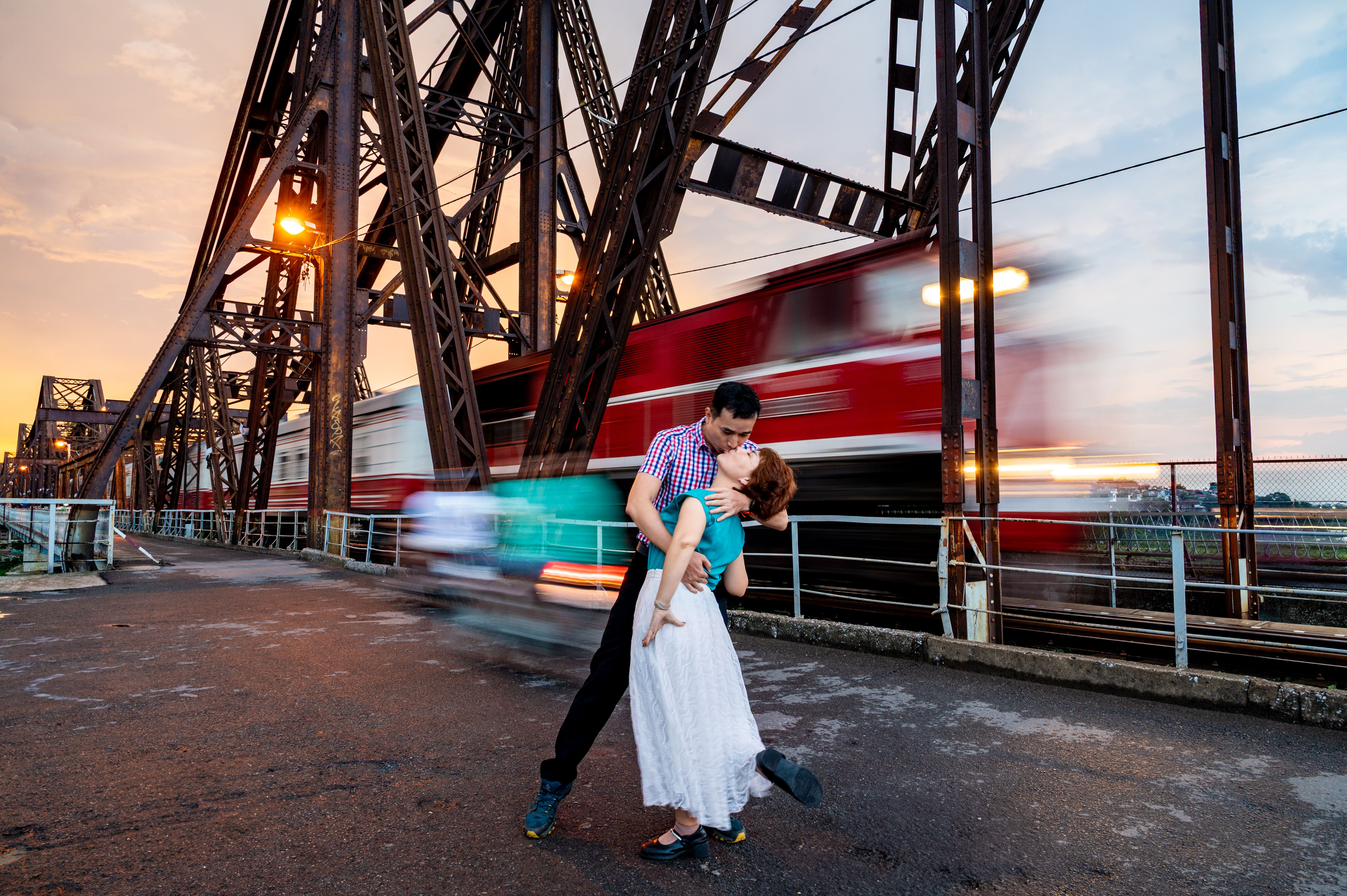 Romantic Couple Kissing on a Historic Bridge at Sunset · Free Stock Photo