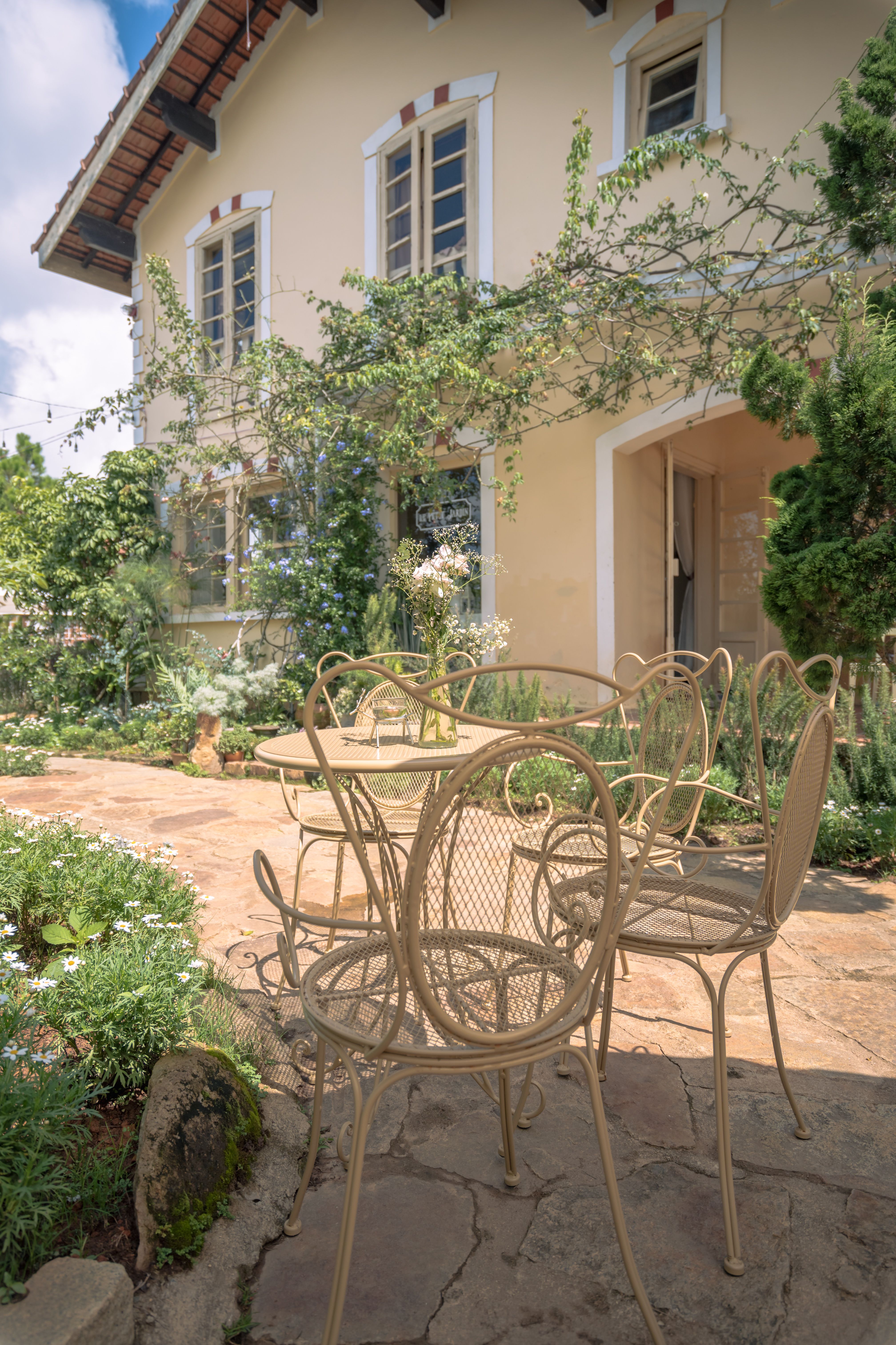 Charming Patio with Vintage Chairs and Lush Garden · Free Stock Photo